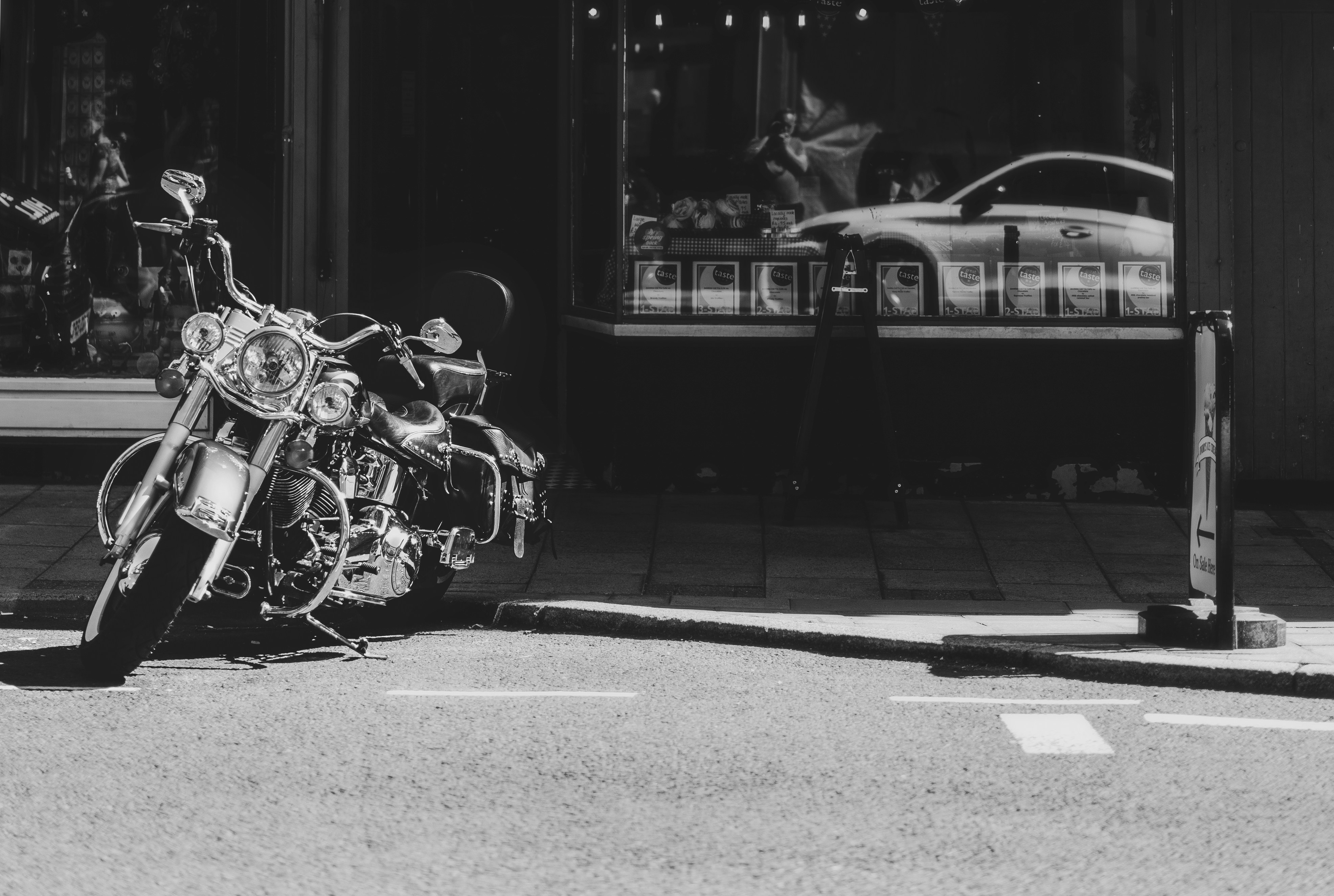 Chrome Meets Street: A Lone Motorcycle Resting by a Glass Shopfront