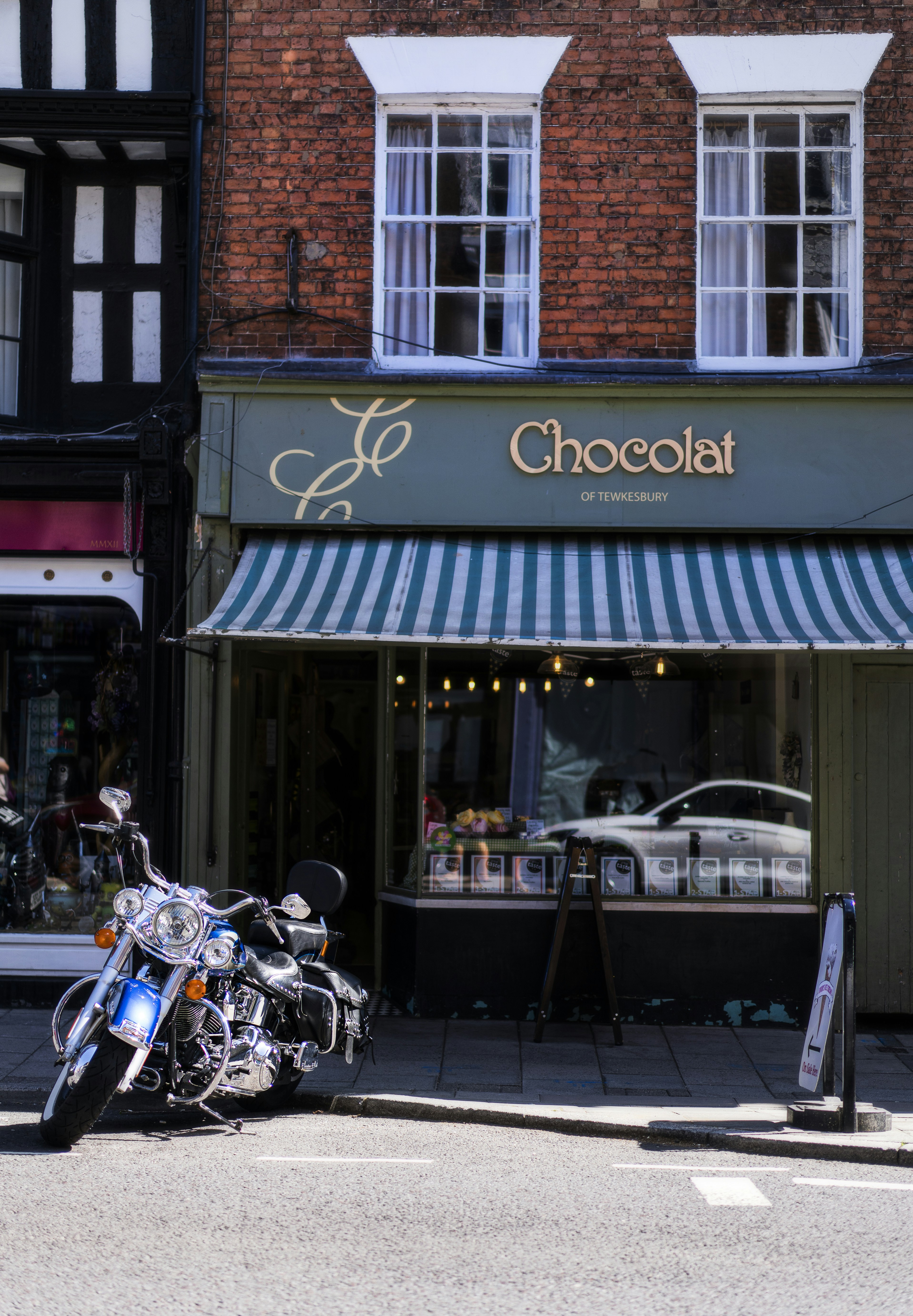 Charming Chocolat Barfront with Striped Canopy and Vintage Motorcycle