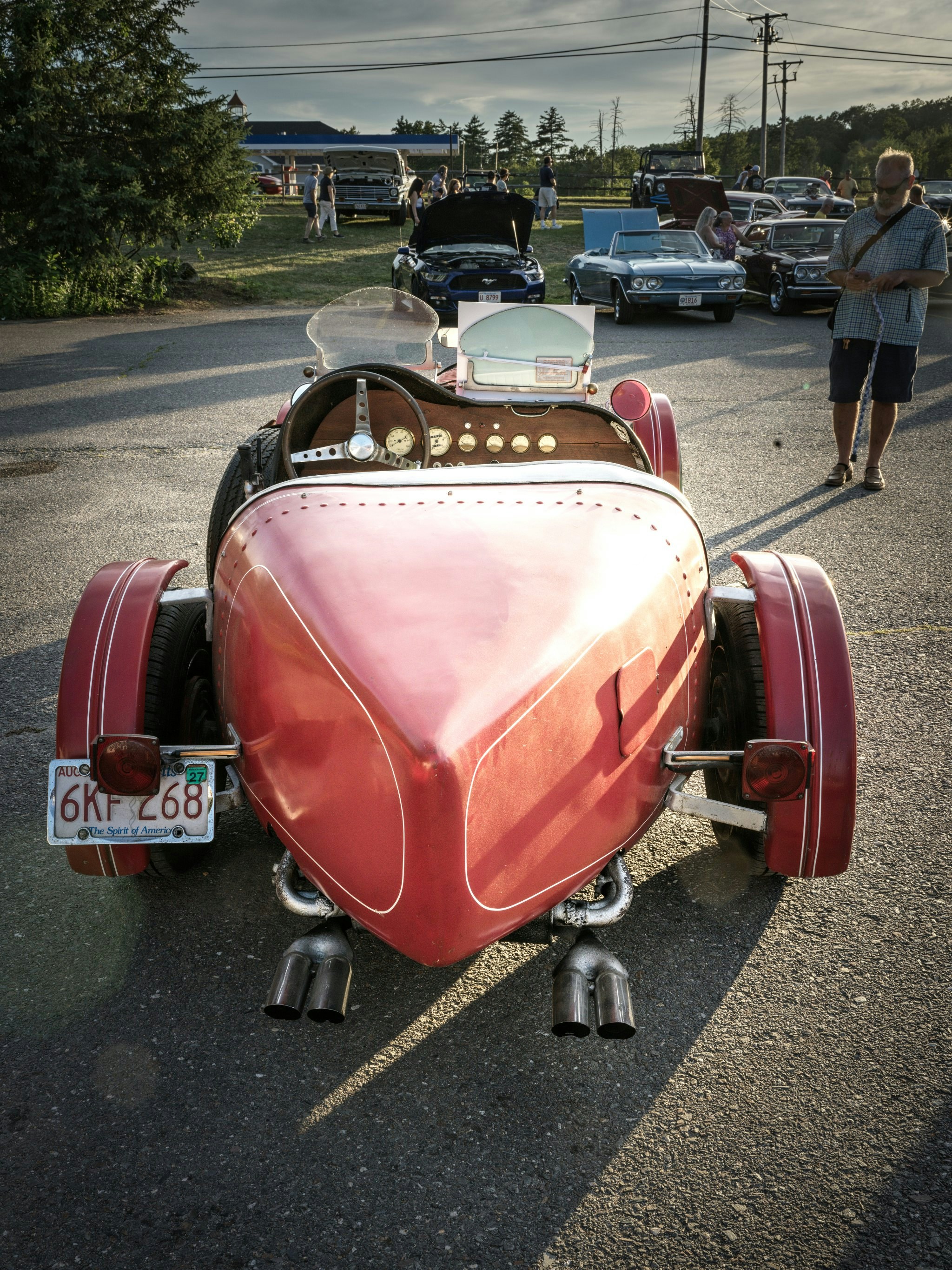 Red Vintage Roadster—Centered in a Sunlit Car Show scene