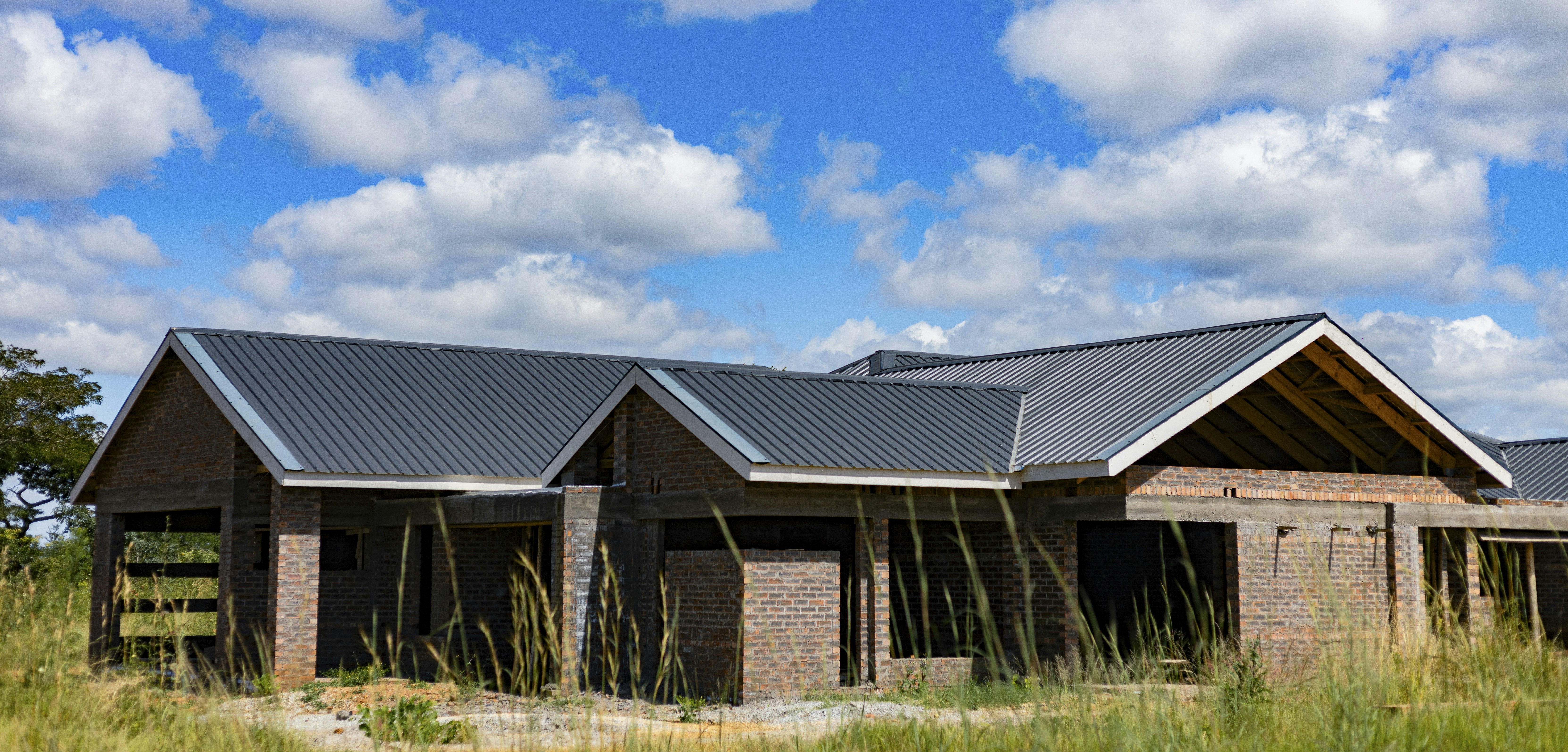 Unders construction: brick shells rise beneath a bright sky