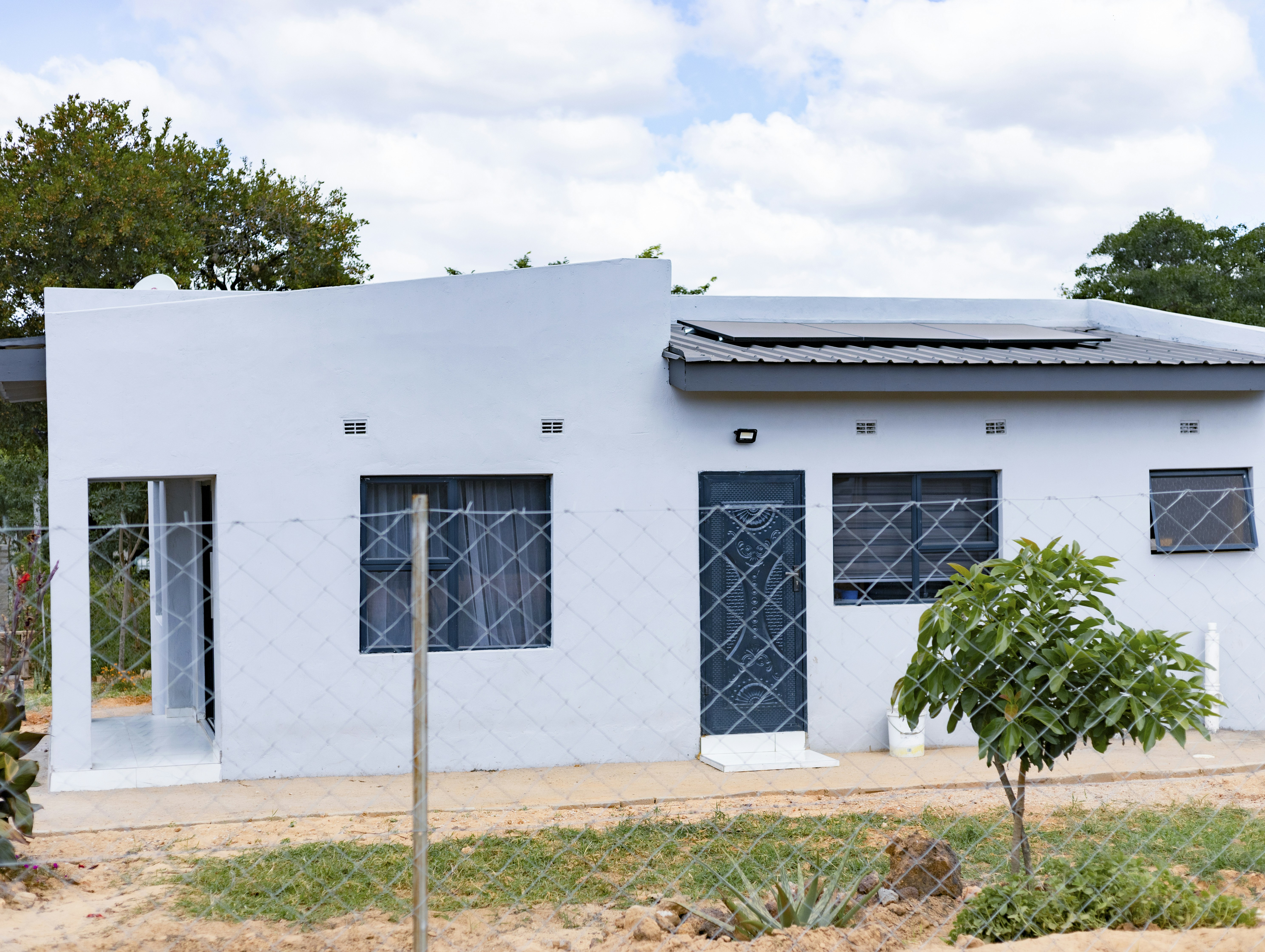 Whitewashed Frontage with Barbed Gate and Sparse Landscaping