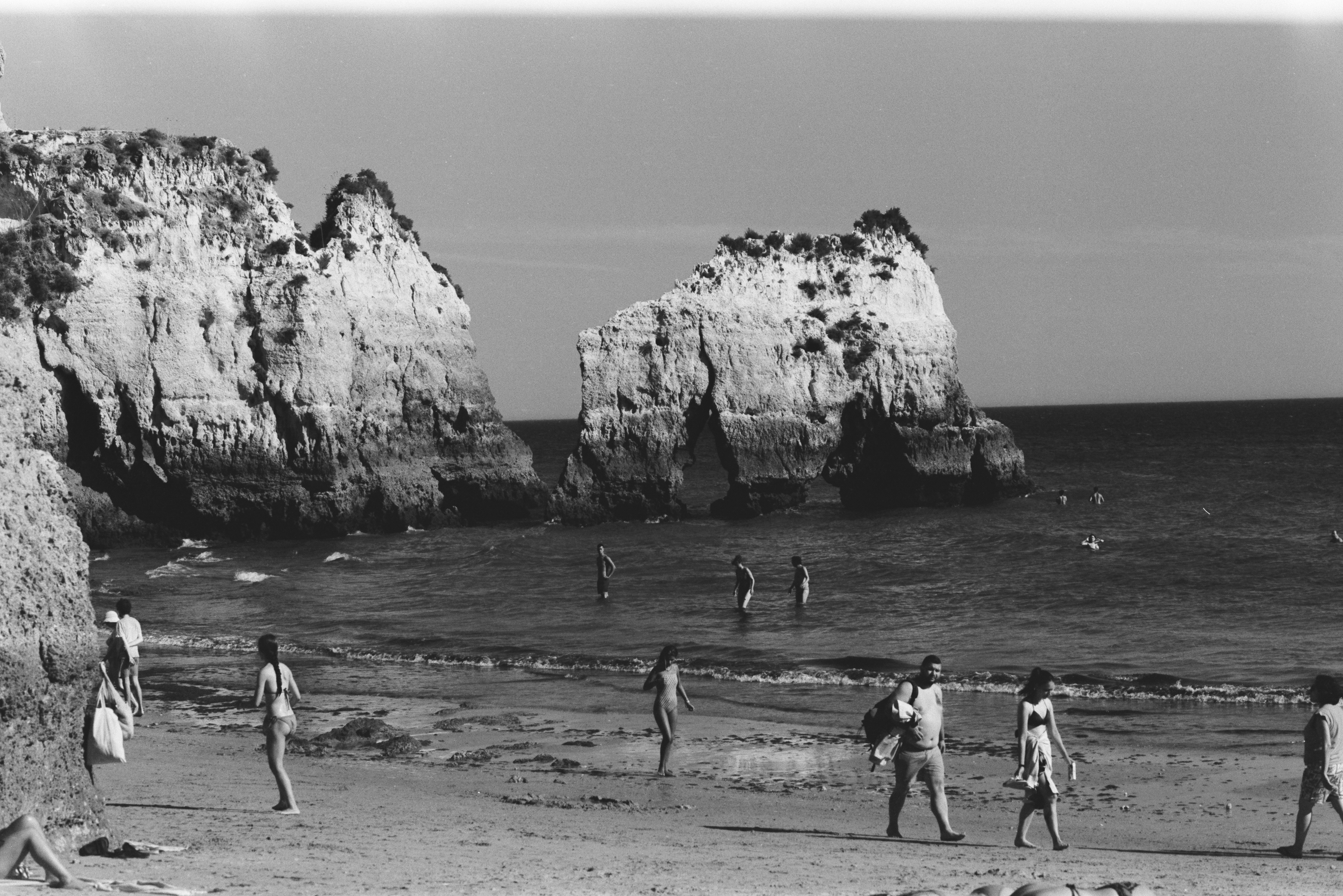 Beachgoers at the Foot of Sea Stacks in Monochrome