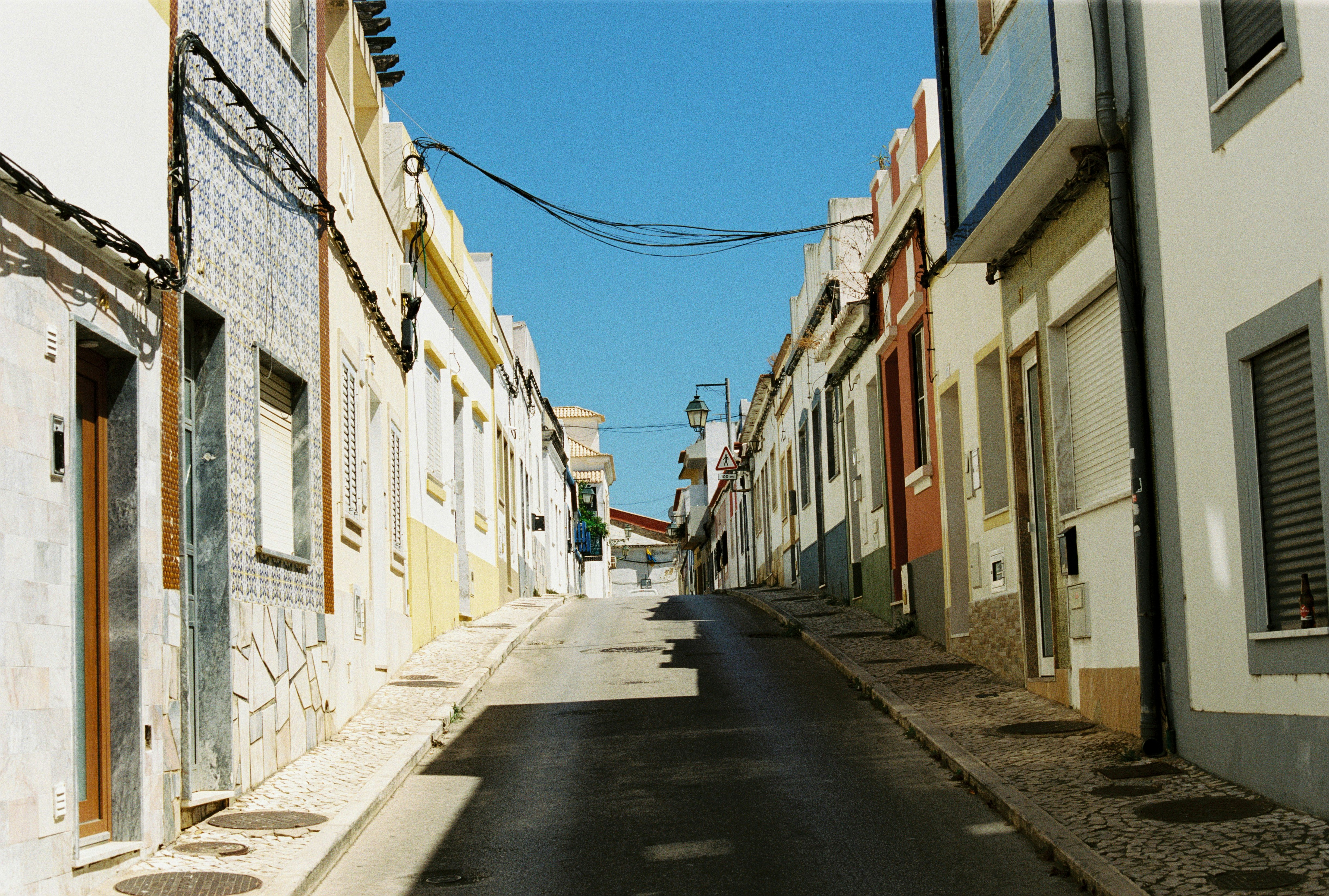 Sunlit Village Street Descends Toward the Sea