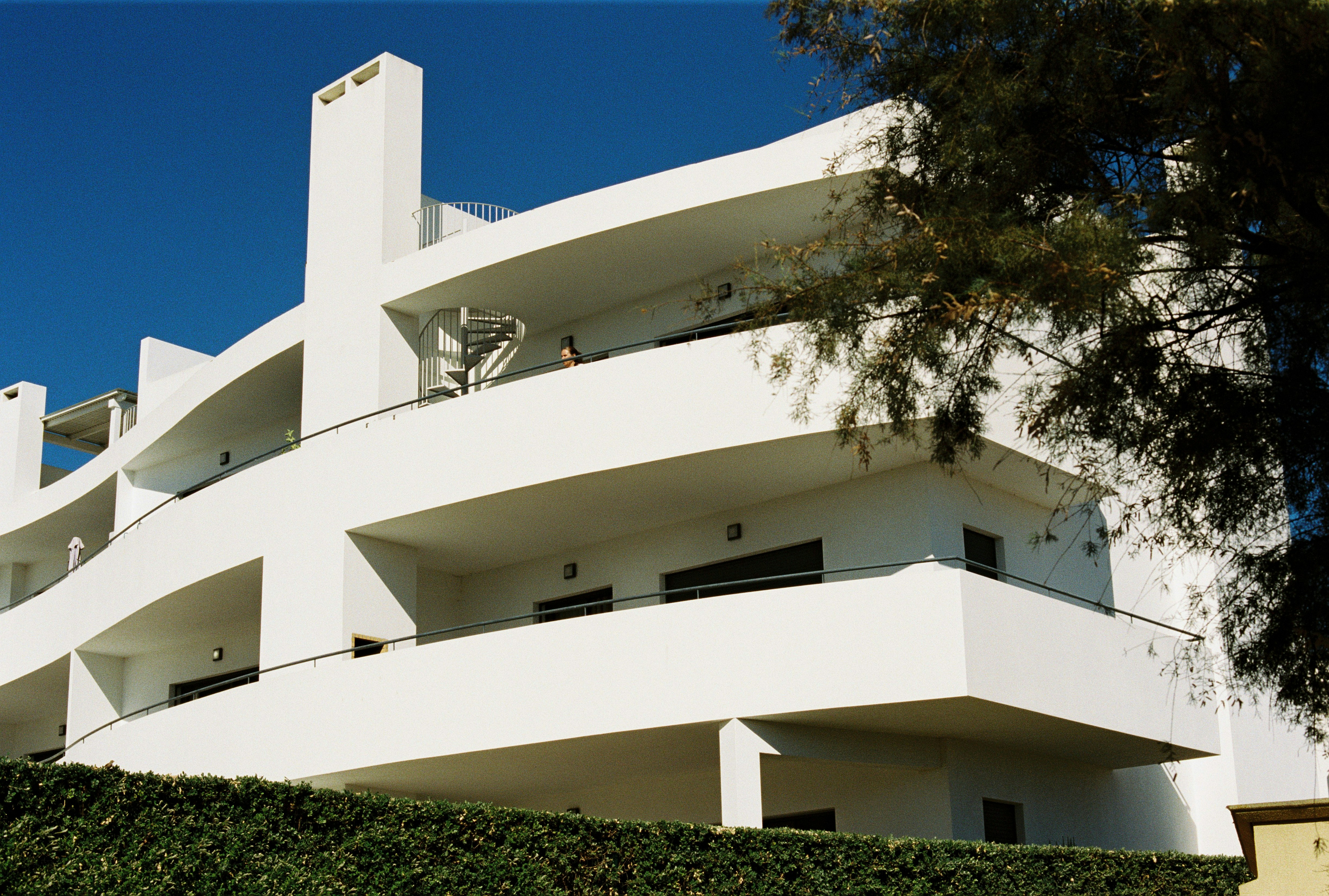Curves in White: A Modernist Terrace Basks Under a Quiet Blue Sky