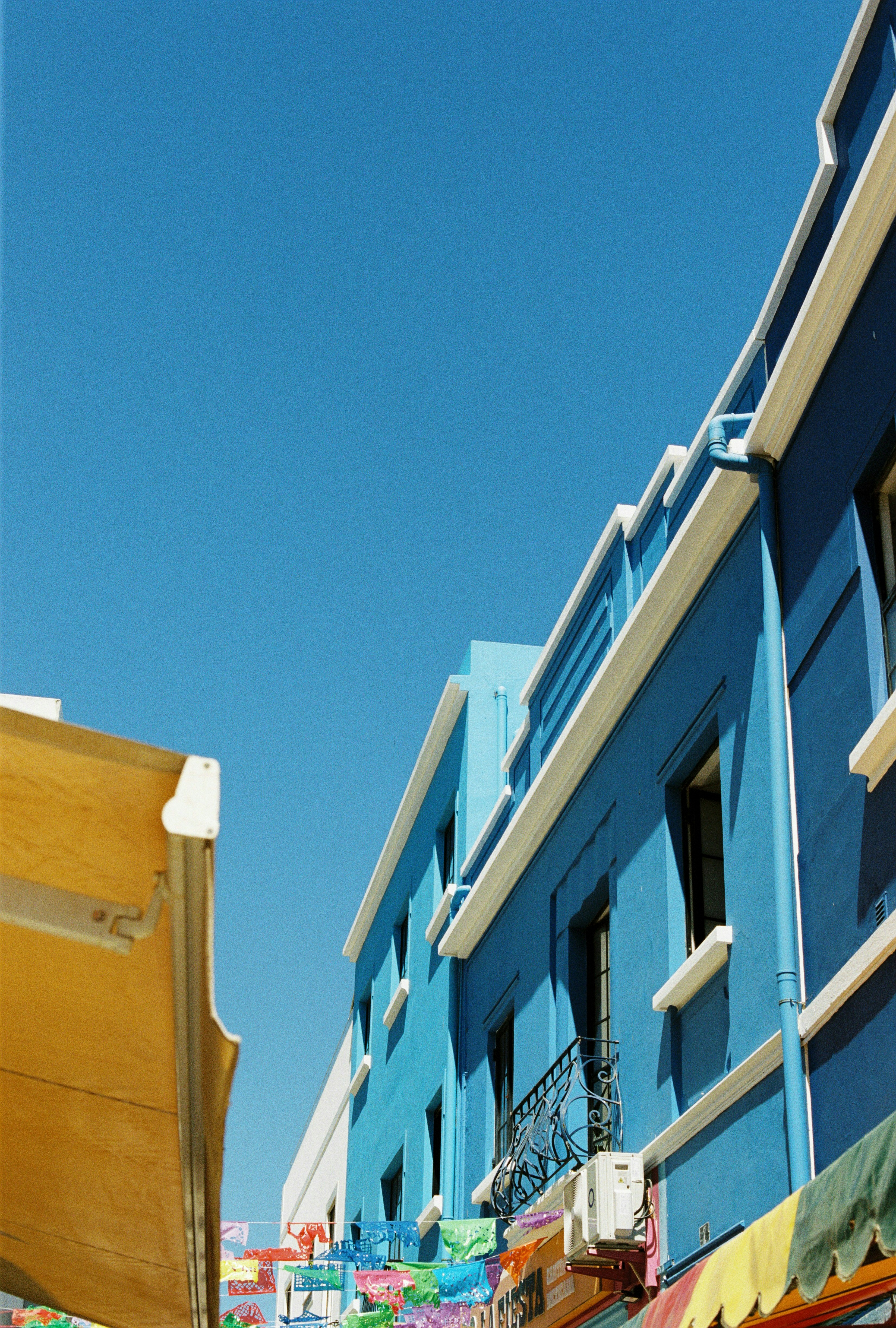 Blue Facade Chronicle: A Sunny Street Quietly Framed
