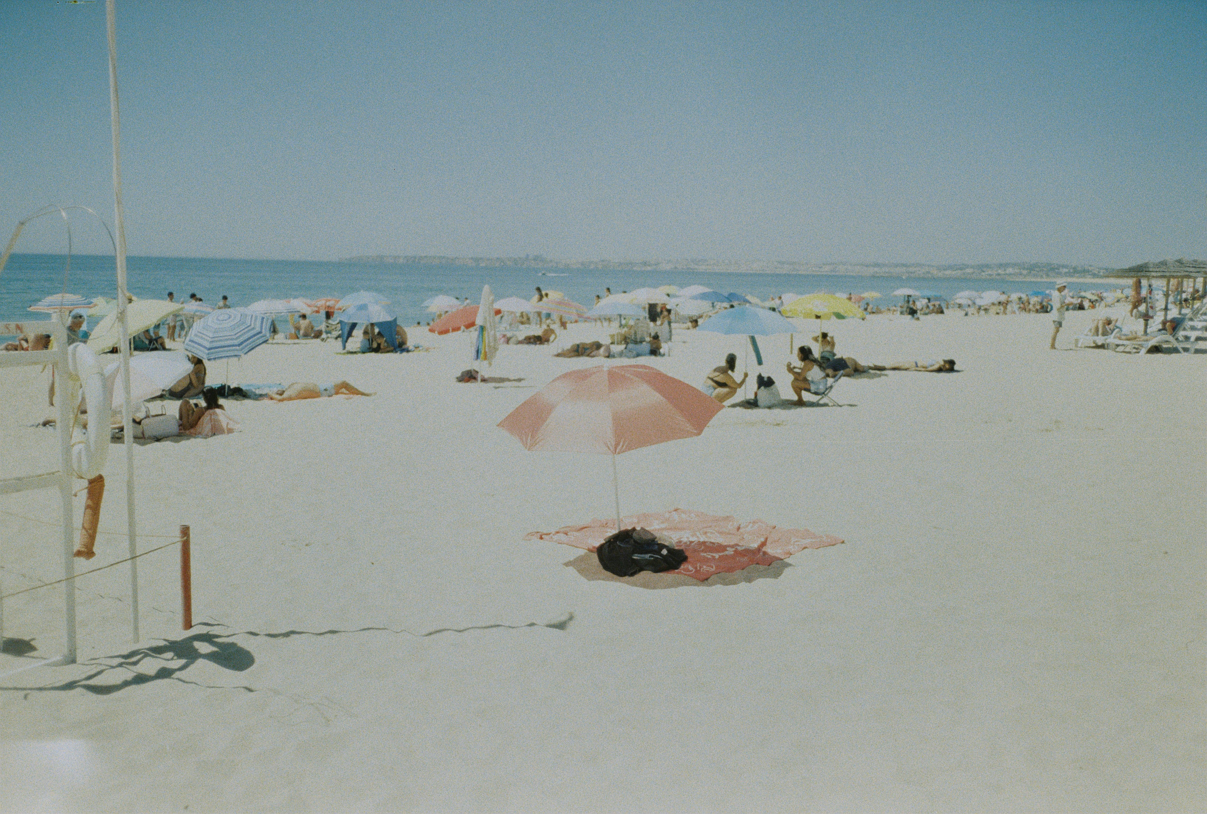 Sunlit Beach Mosaic: Umbrellas, Sand, and Sea