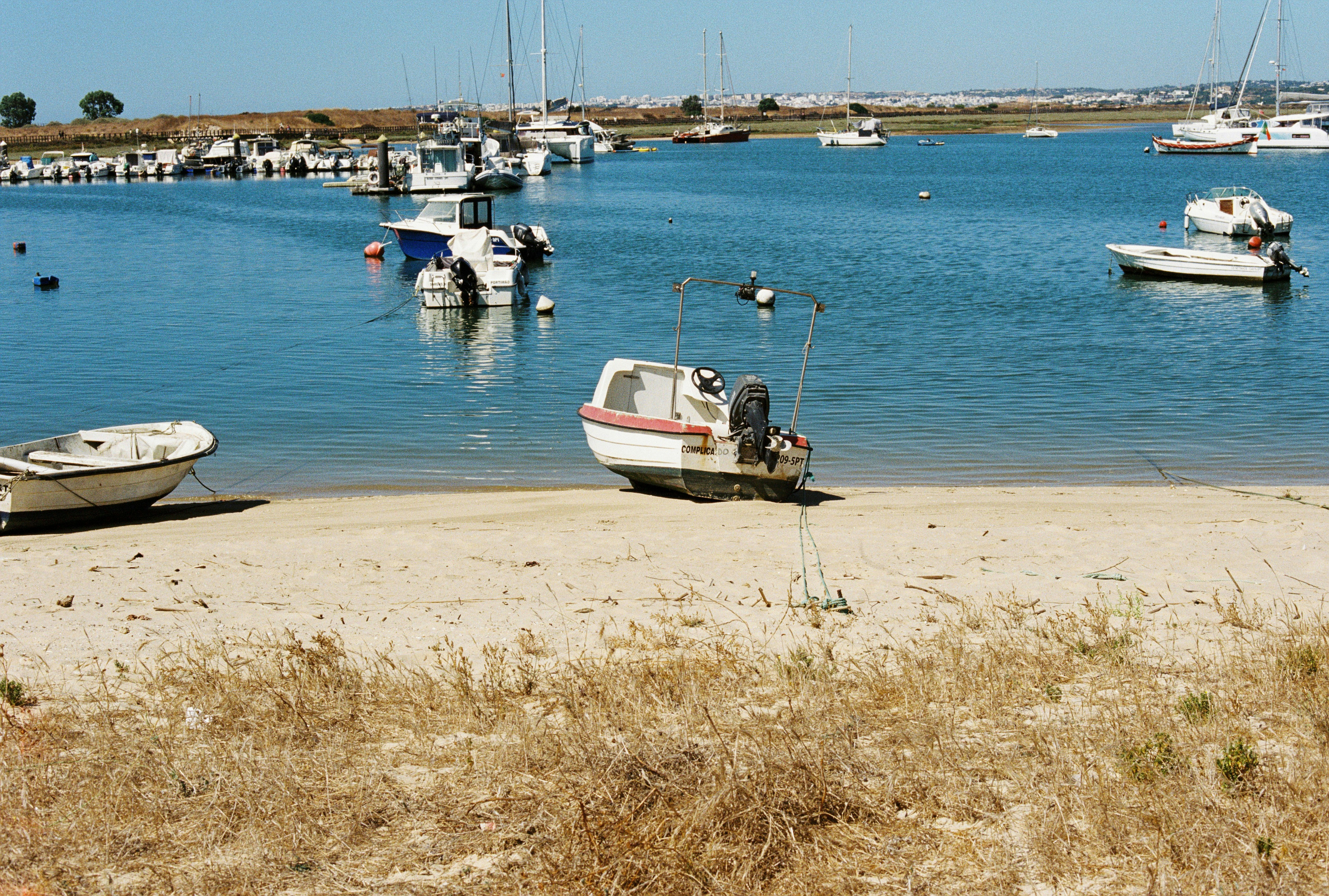 Boat at Rest on Sandy Crest Near a Quiet Harbor