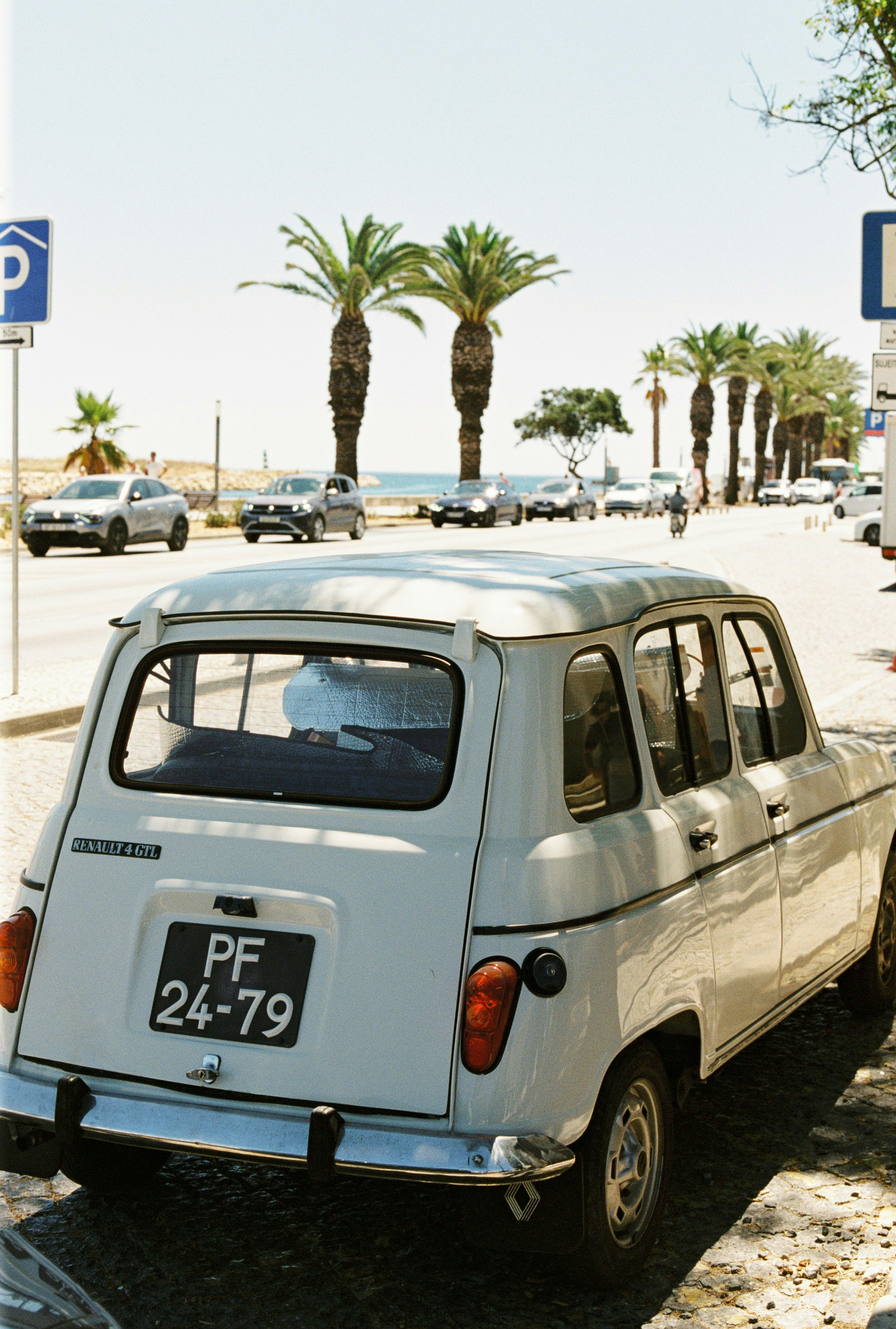 Pastel Coastal Road: A White Classic Car at Sunset Parking