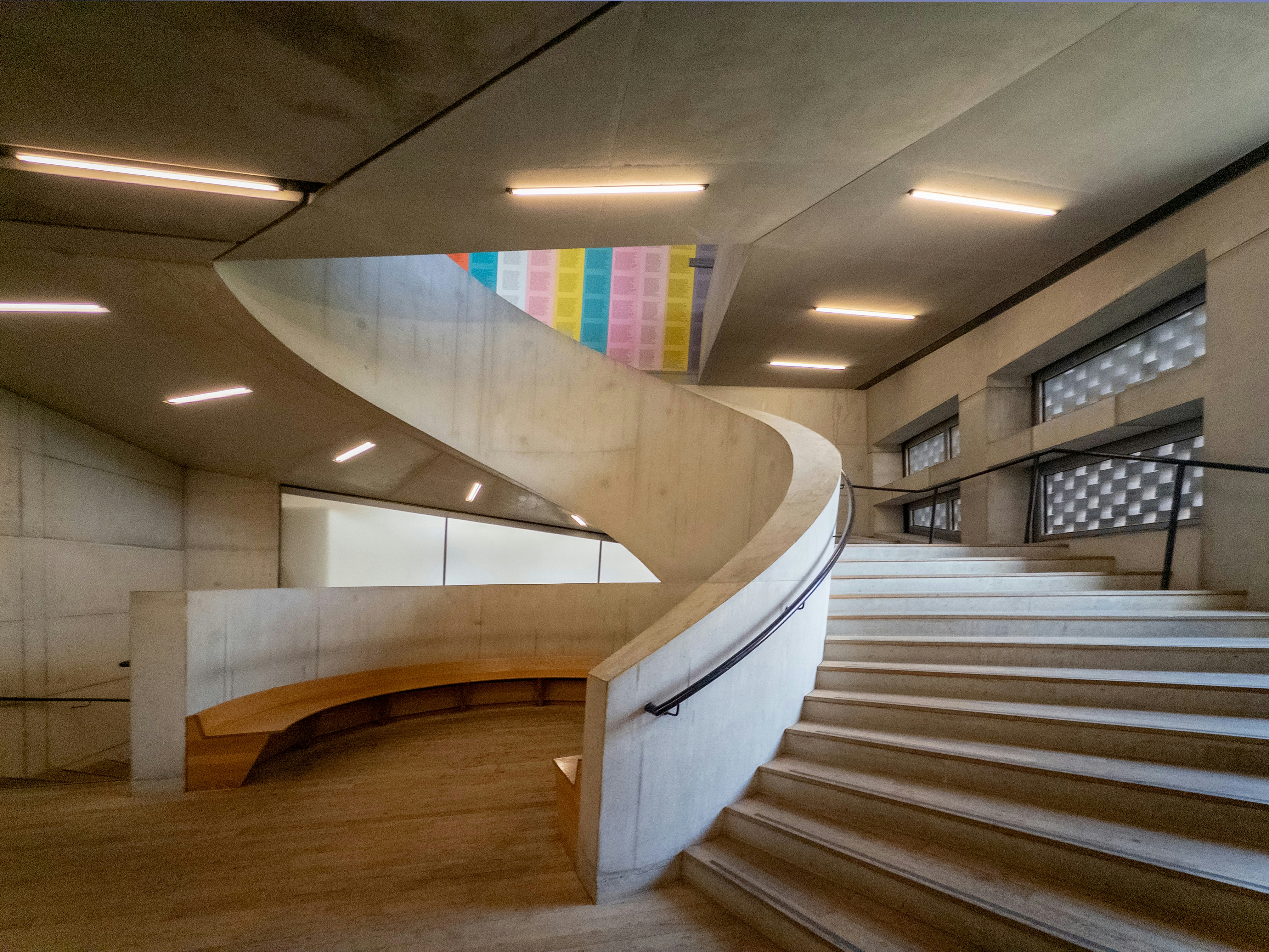 Spiraling Concrete Staircase Bends Through Quiet Suburban Architecture