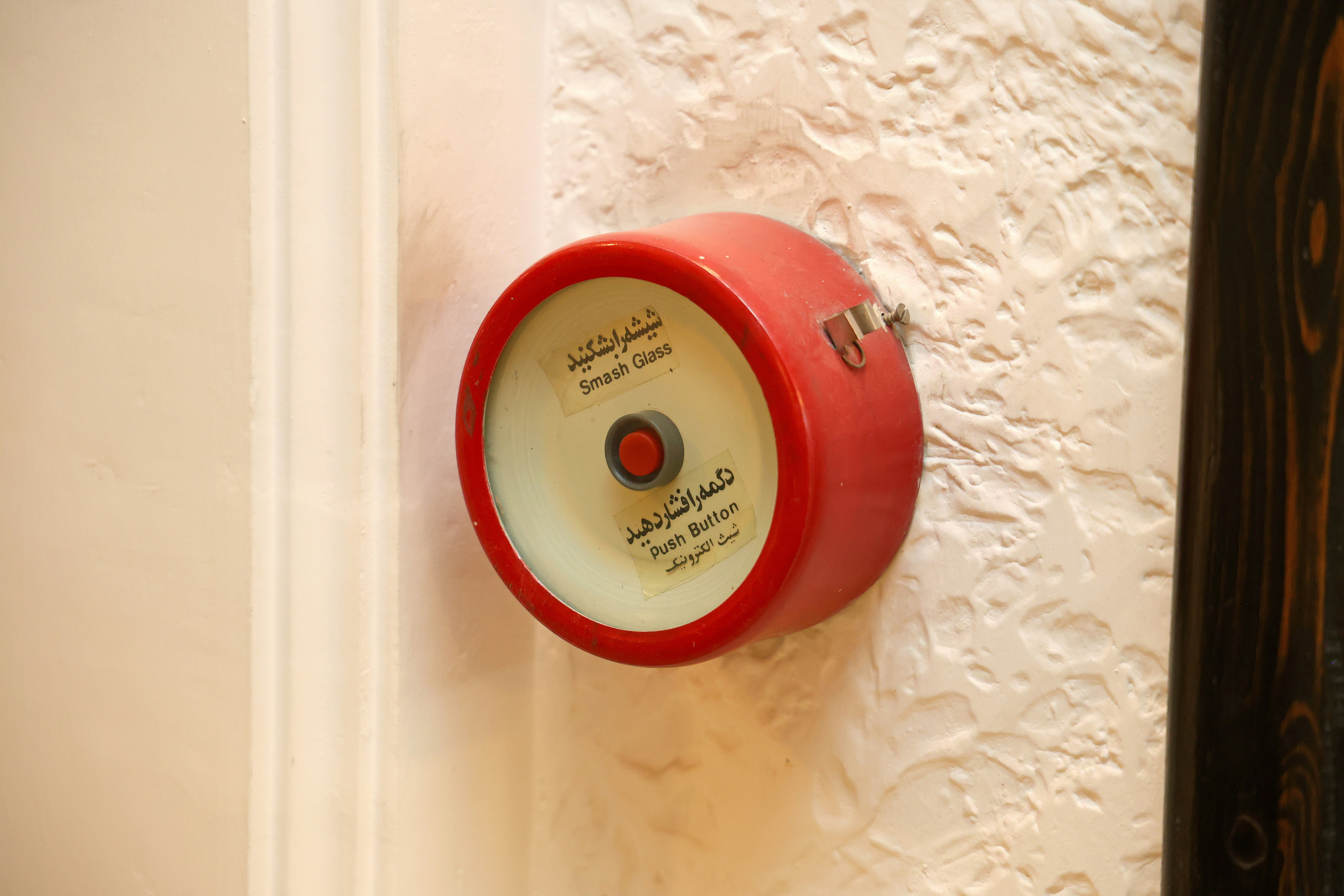Red bell-stationed beacon on textured wall