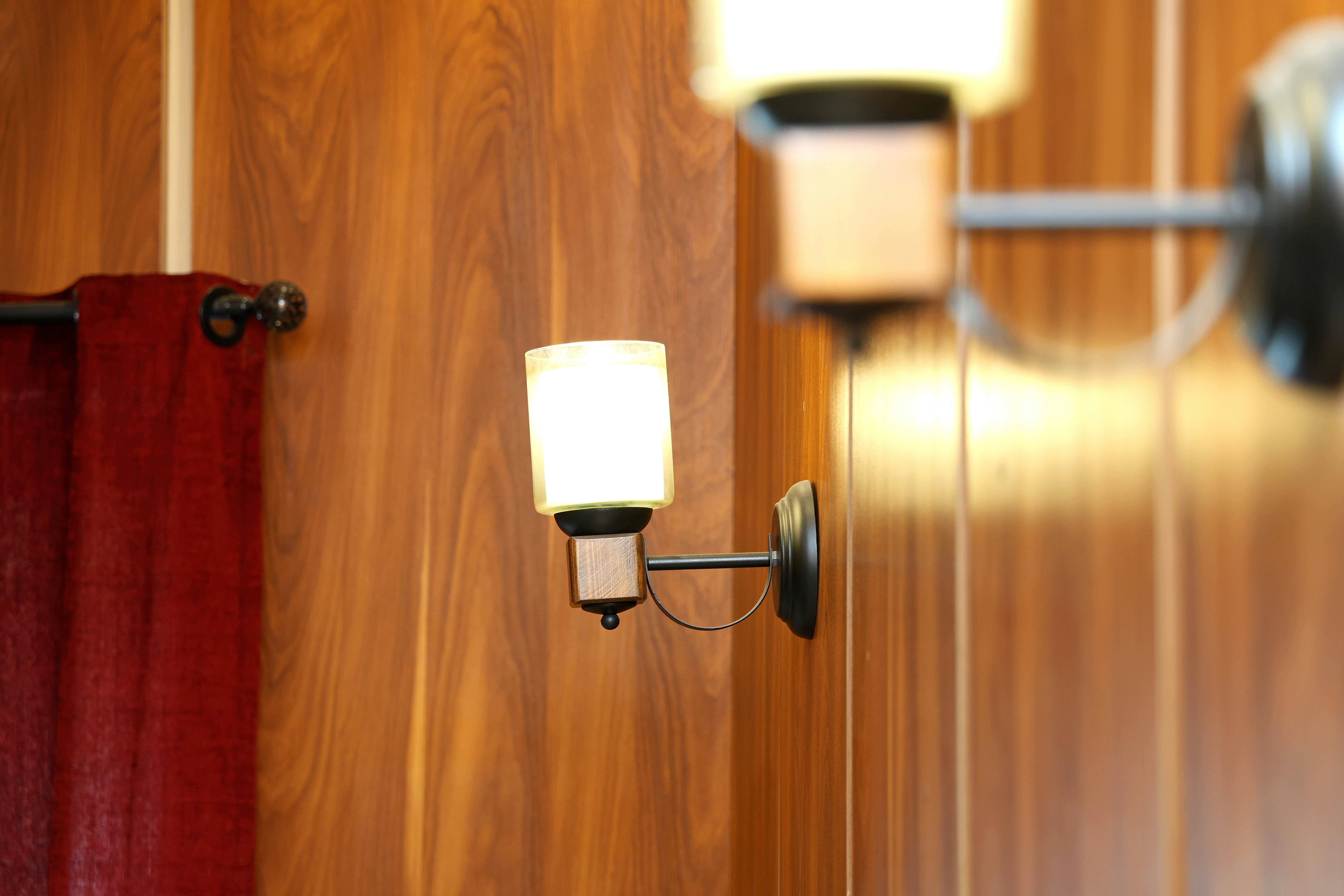 Warm Glow on Wood: A Wall Lamp in a Mid-Century Hallway