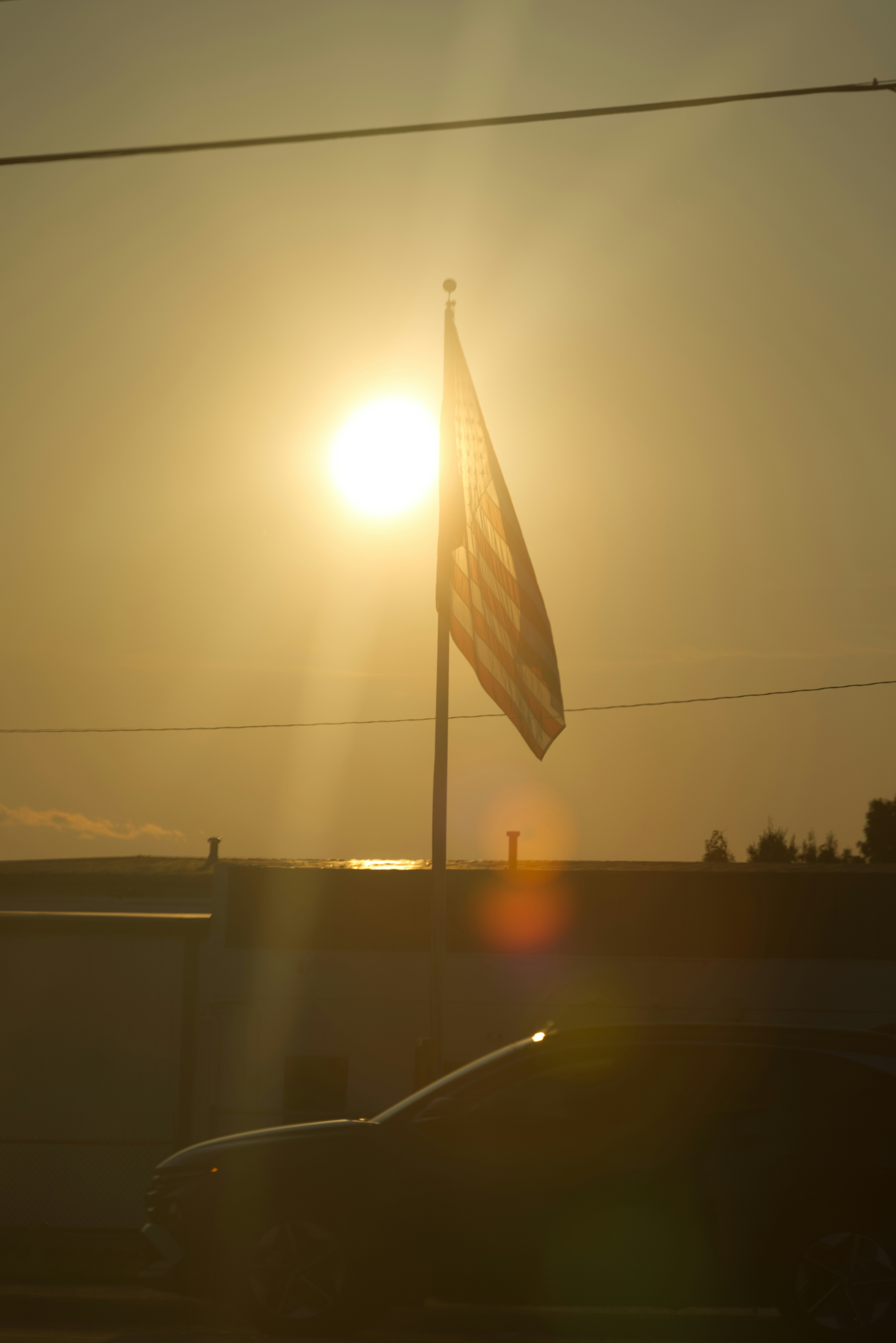 Flag, Sun, and Streetlight: Golden Hour at the Parking Lot