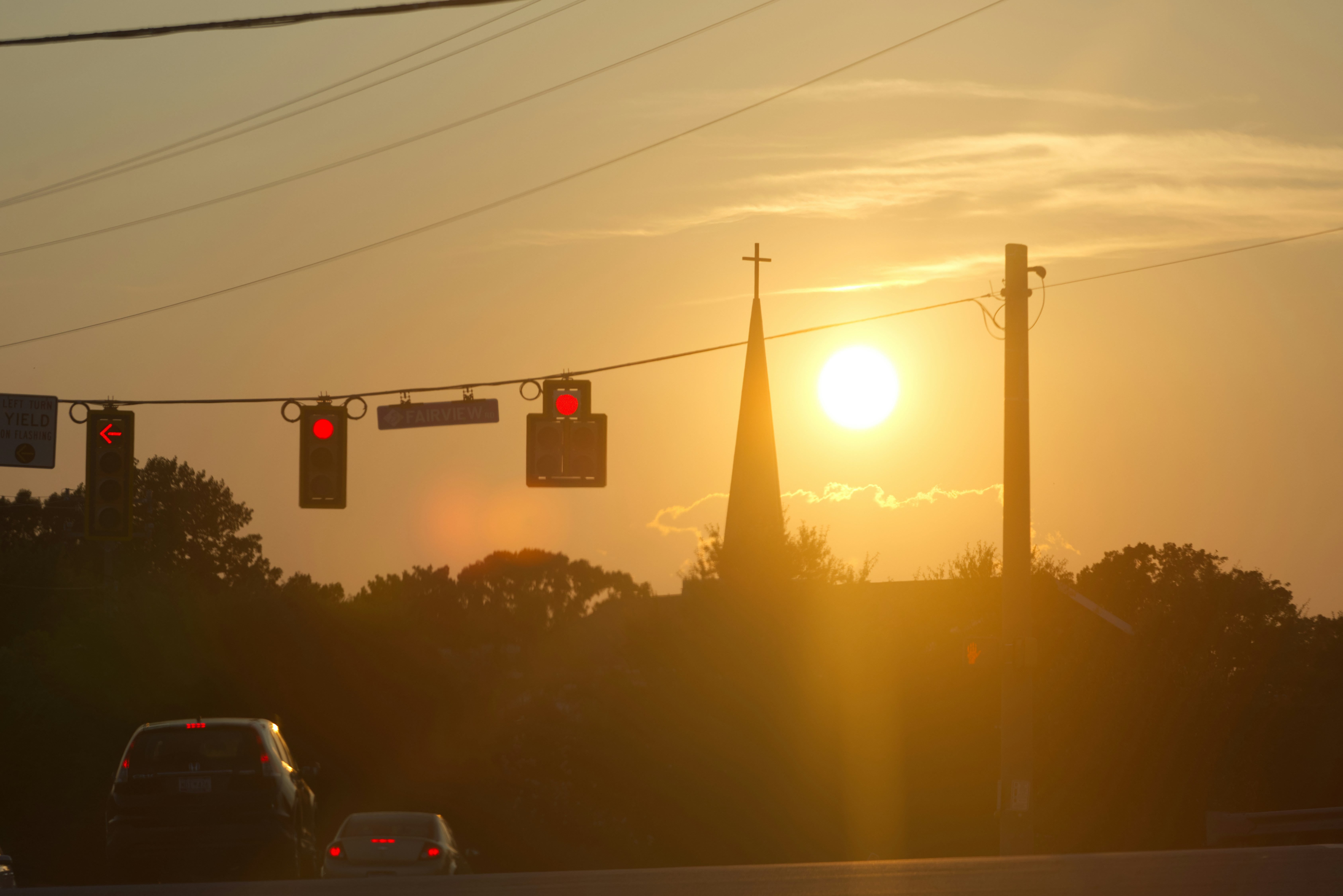 Golden Hour Horizon: Sunset Traffic & Church Spire Silhouette