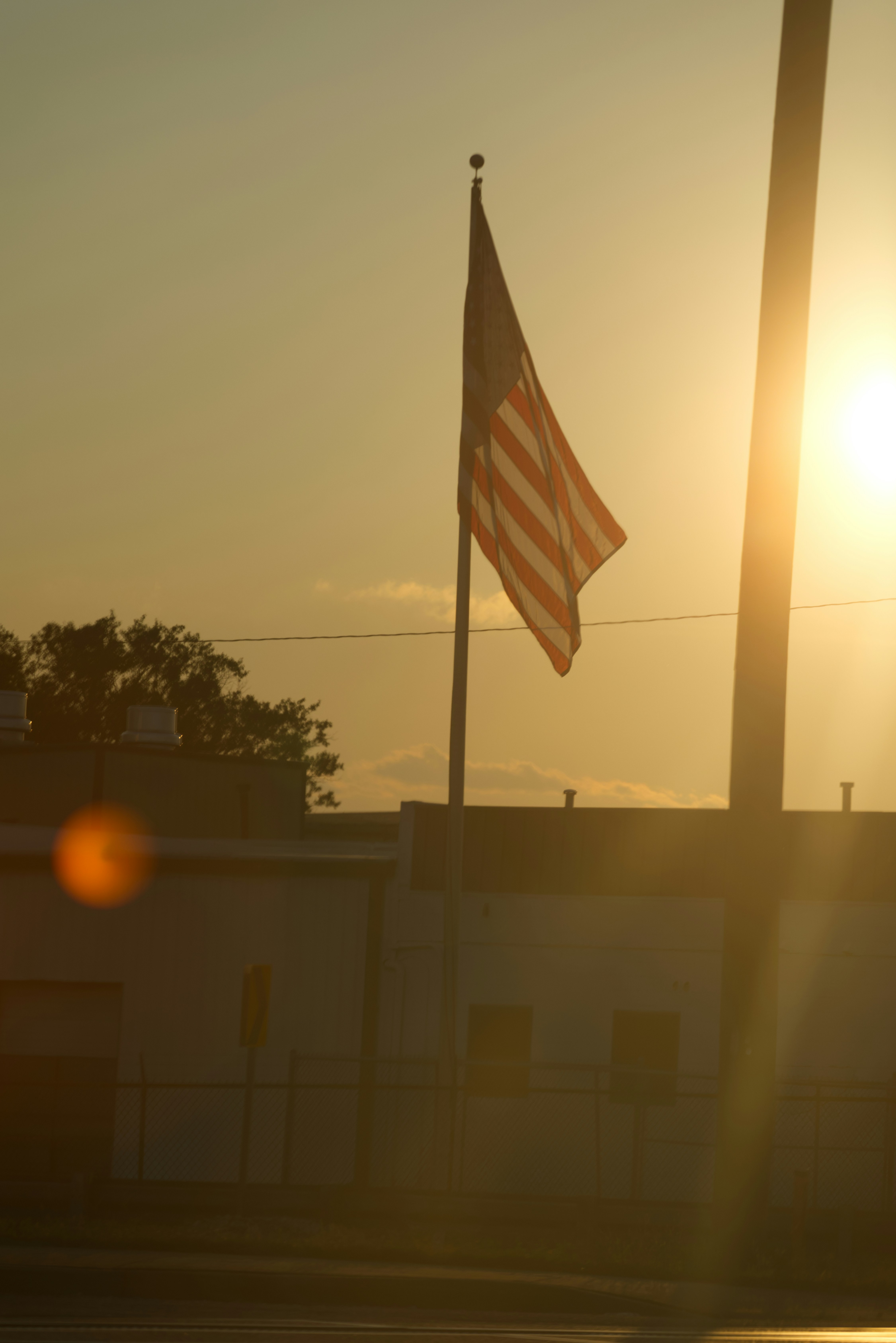 Flag in golden hour over a quiet industrial plaza