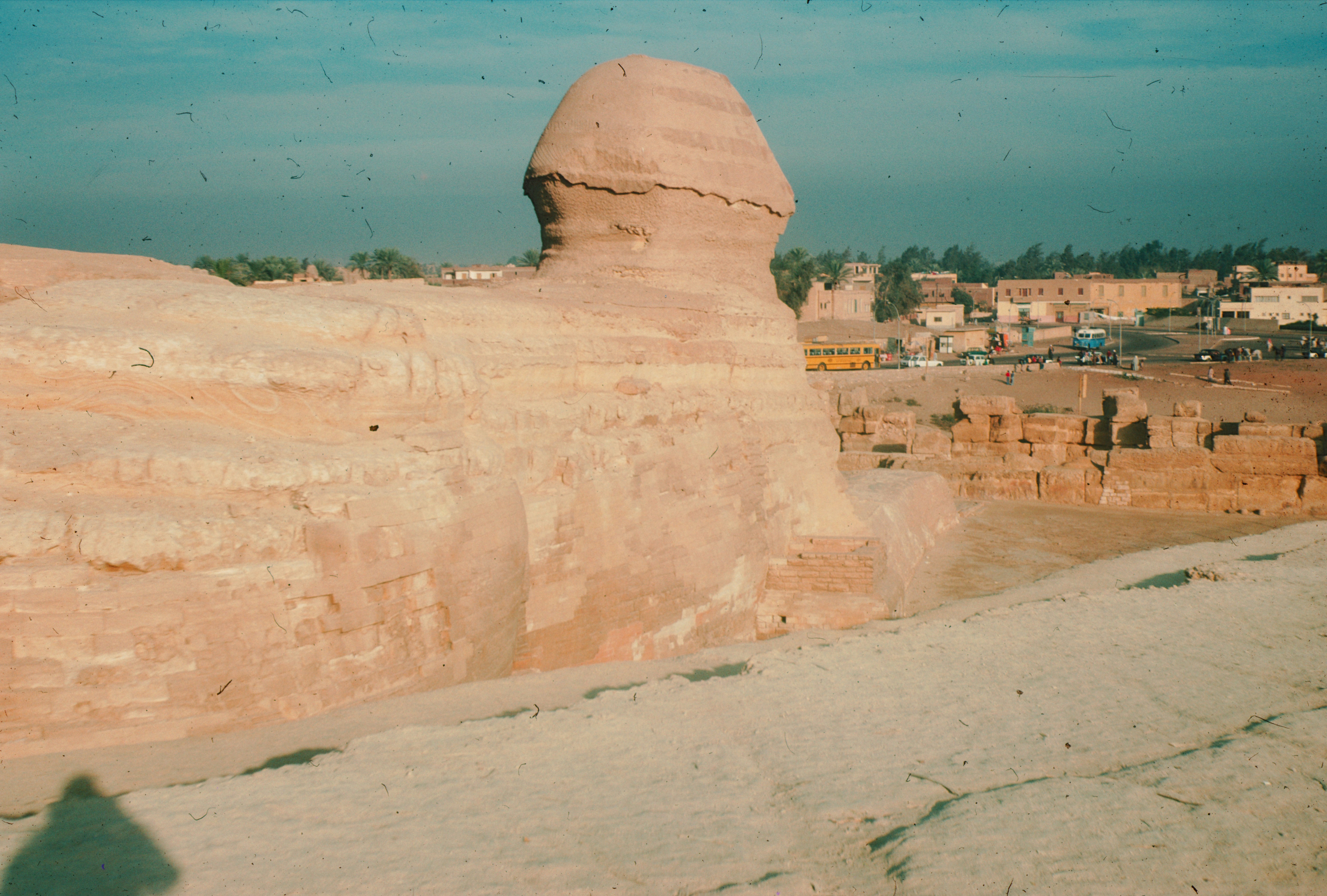 Eroded Sphinx and Coastal Village: Sandstone Formations Framing a Quiet Horizon