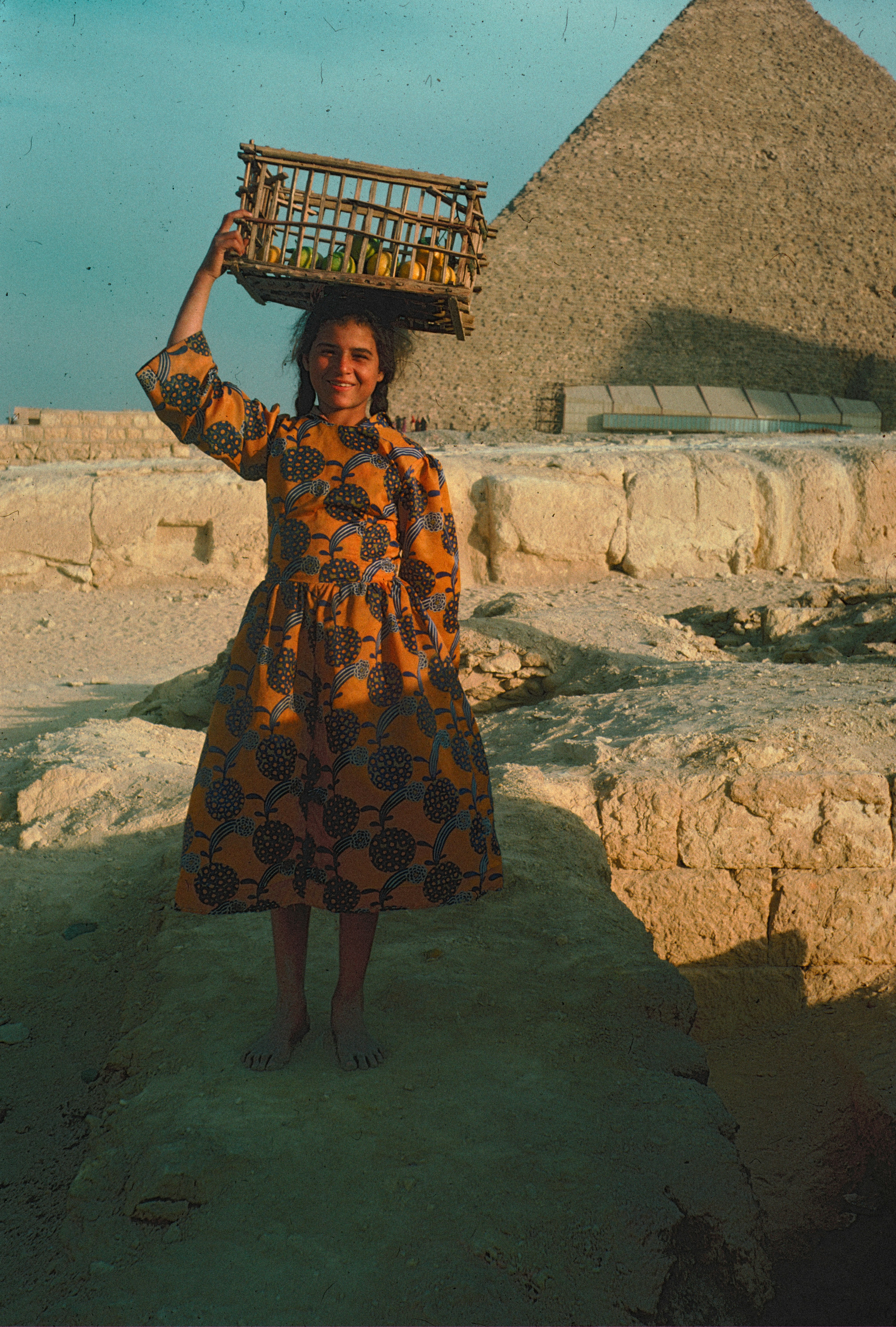 Carrying a Harvest: A Maya Woman Balances a Basket Beneath the Great Pyramid
