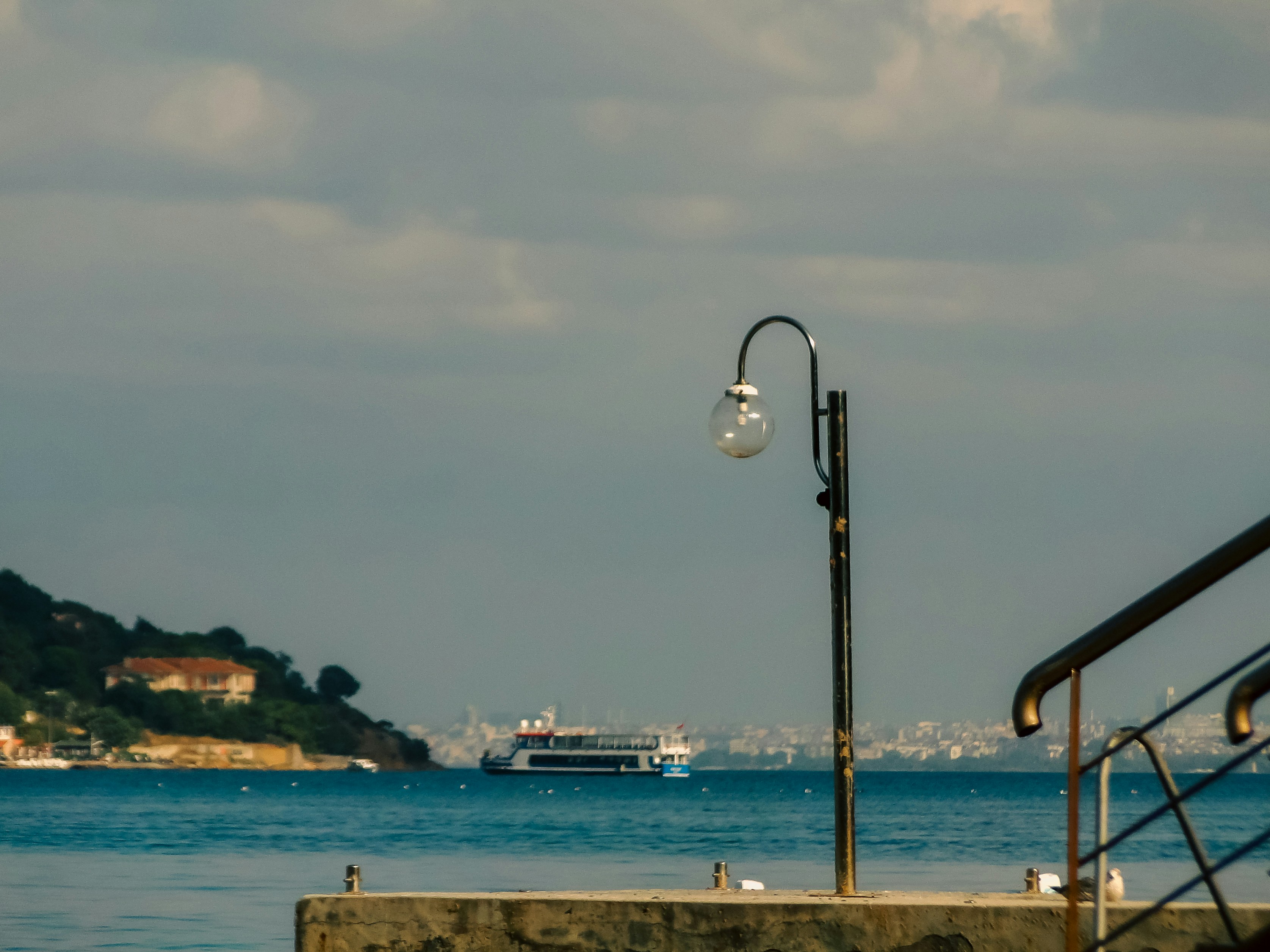 Harbor Lights: A Quiet Pier Framed by a Distant Vessel