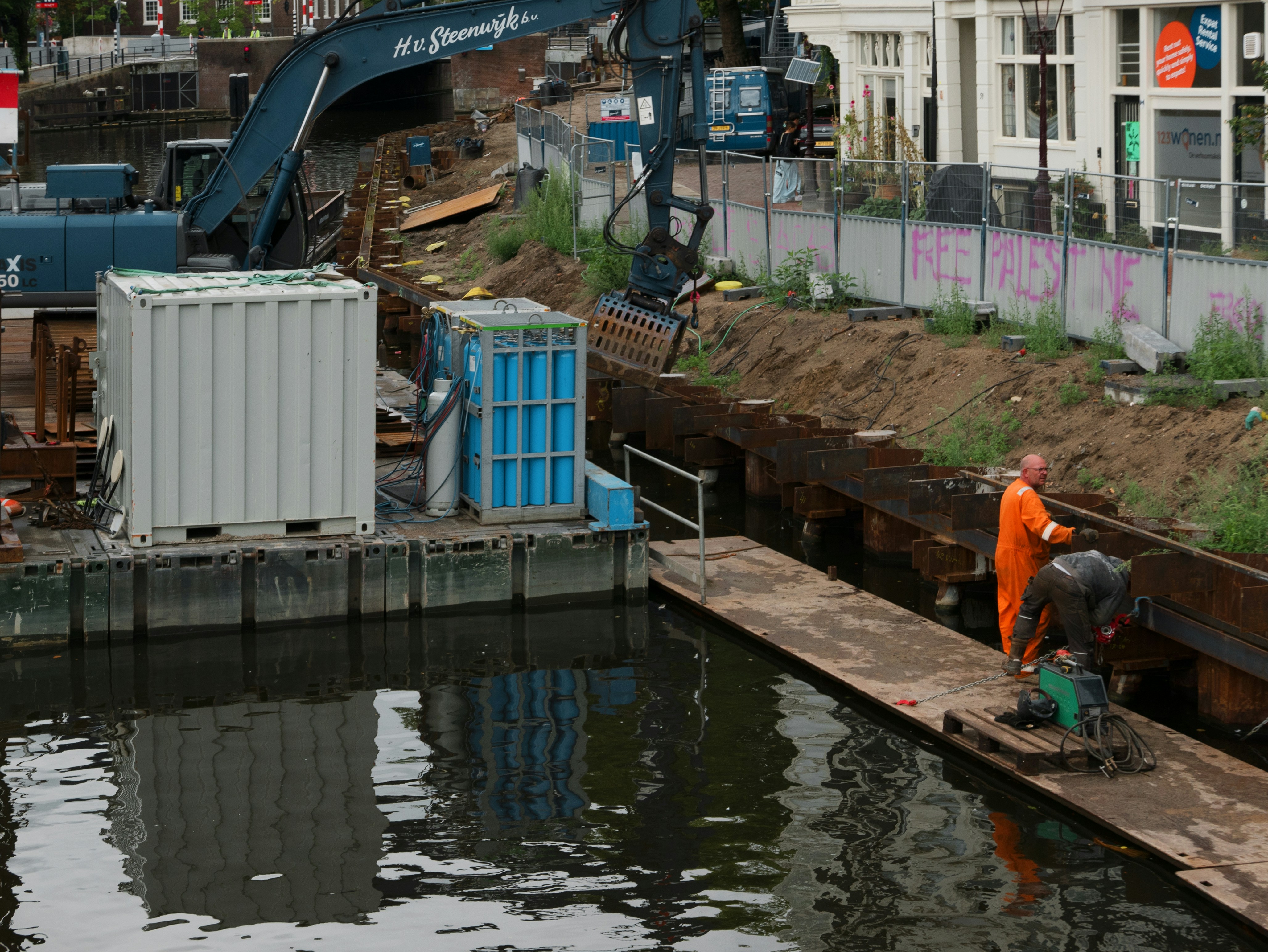 Dockside Construction: Workers on a Narrowbeam Near Water