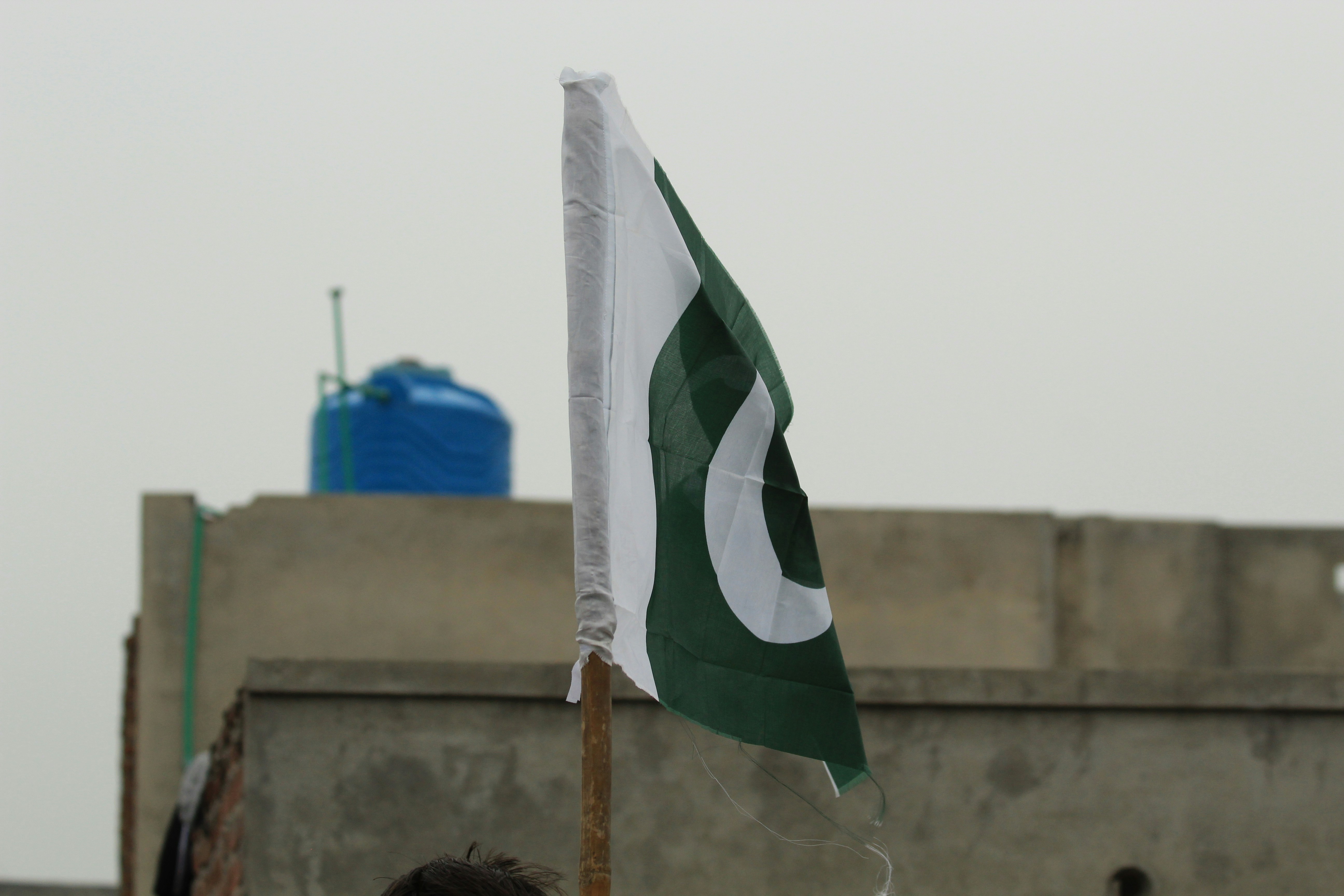Flag on a rooftop: a lone pennant in muted daylight
