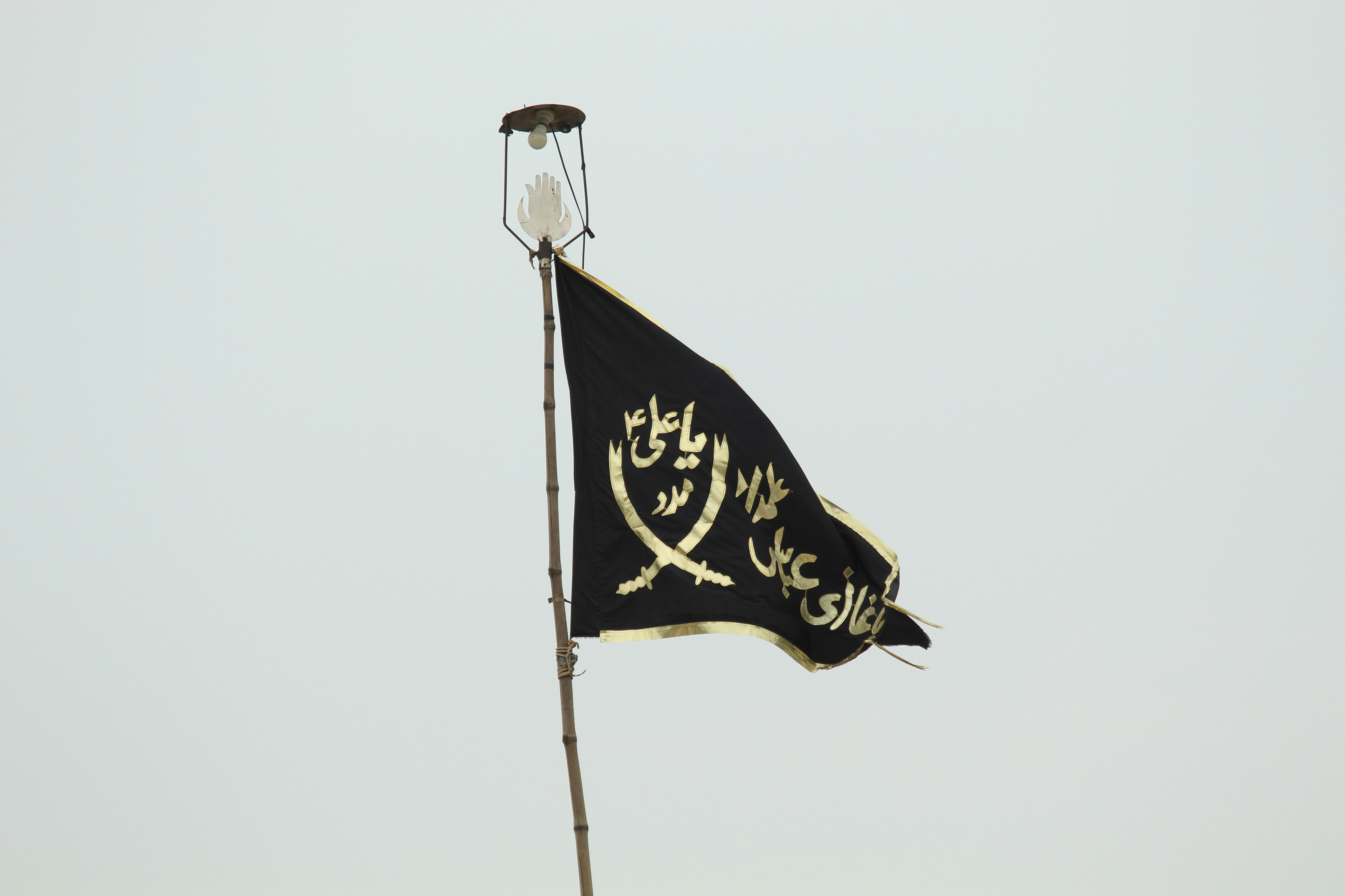 Flag of Faith: A Lone Banner Rising Against a Pale Sky