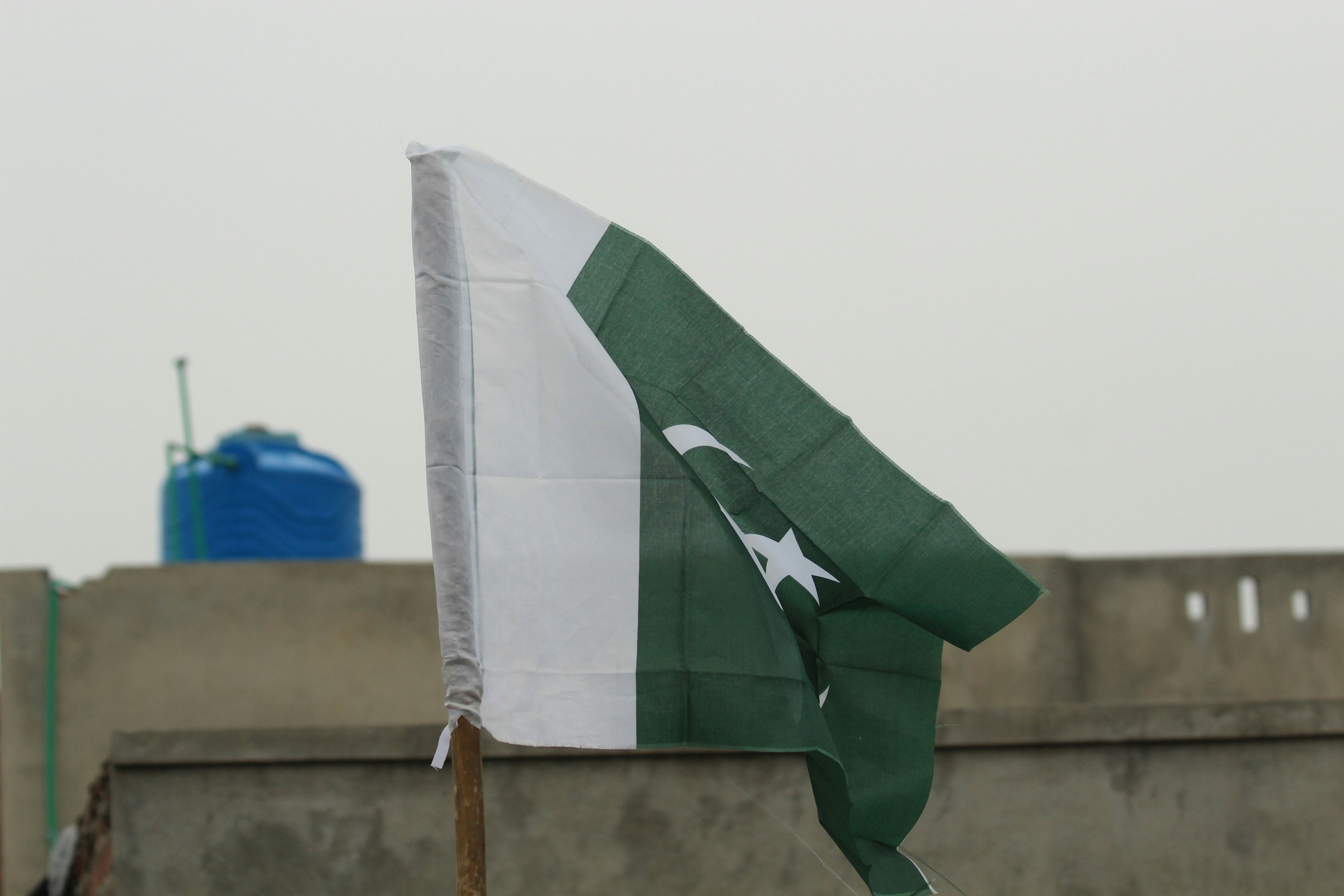 Tattered Flag on a City Rooftop
