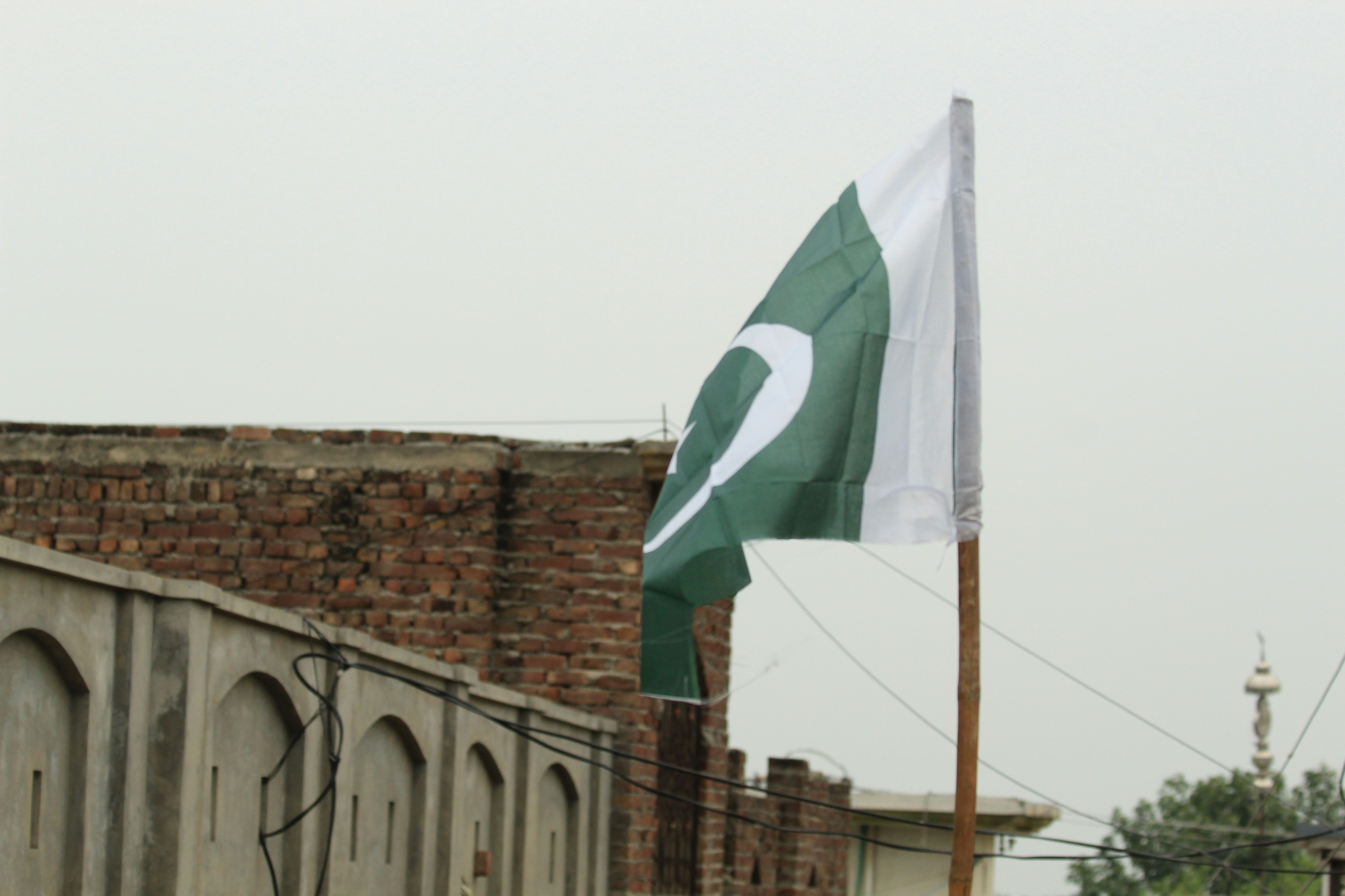 Flag on a Weathered Rooftop: A Quiet Moment with a Green Emblem