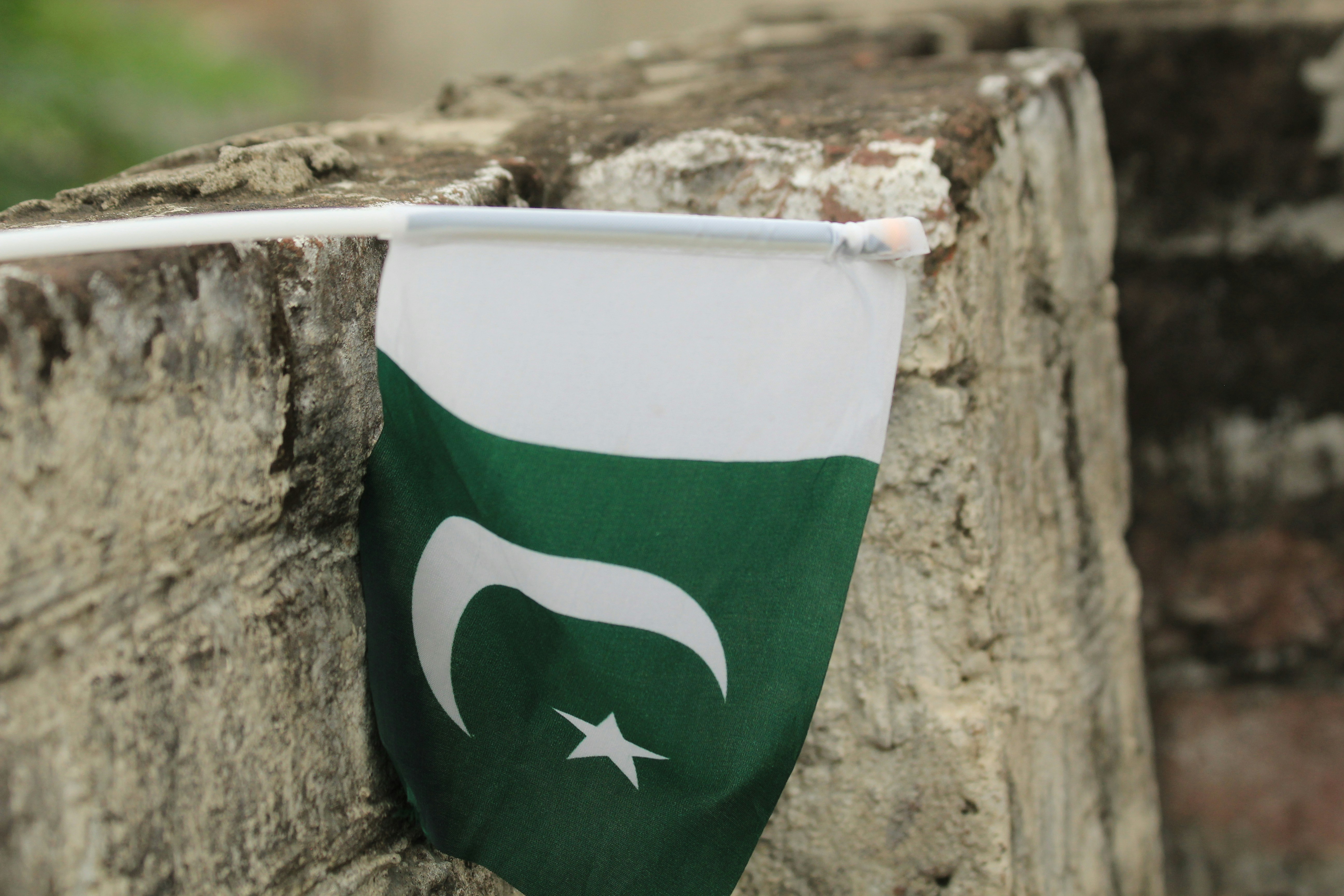 Green Crescent Flag Draped Over Cracked Concrete