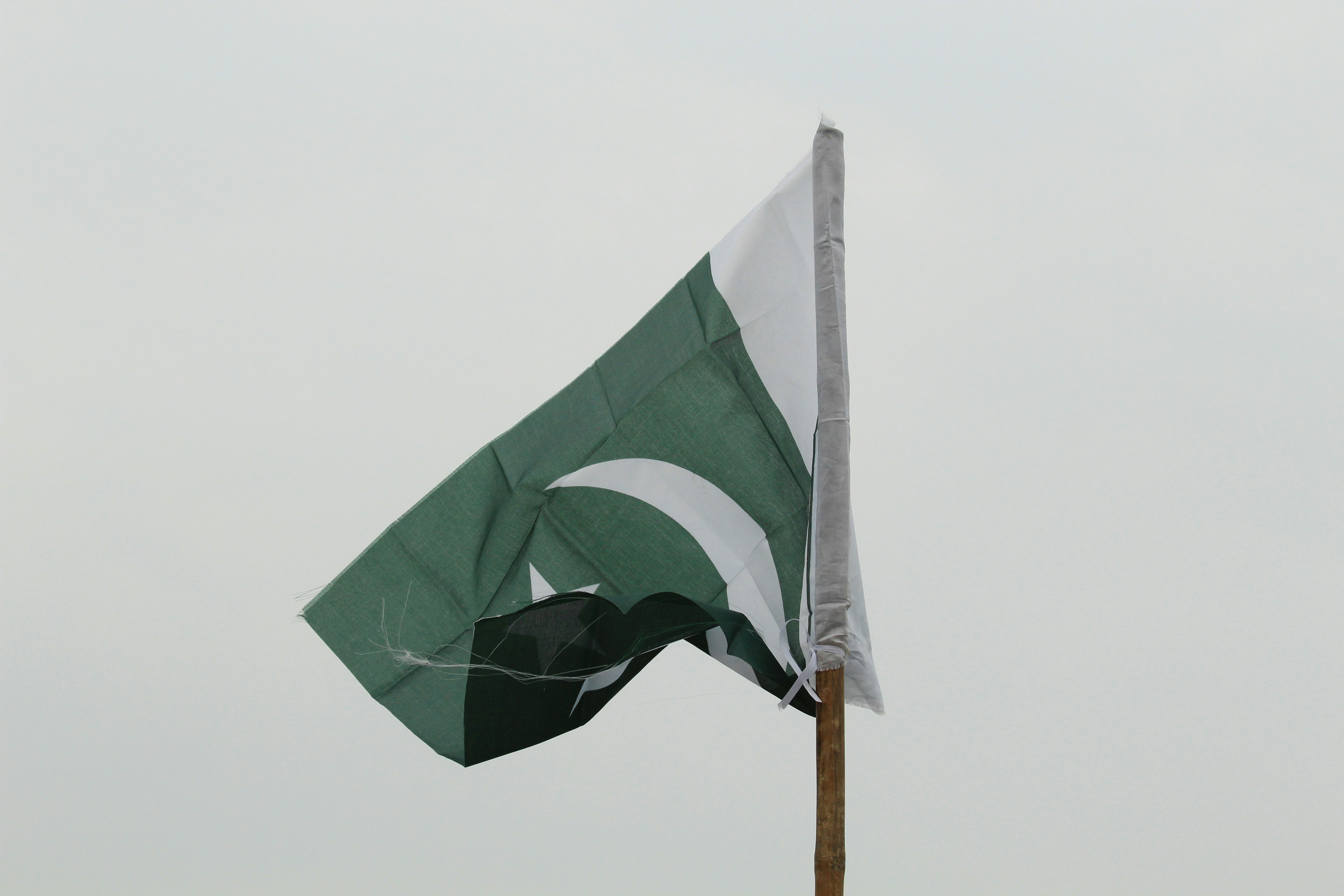 A Waving Crescent: Pakistan Flag Against A Quiet Sky