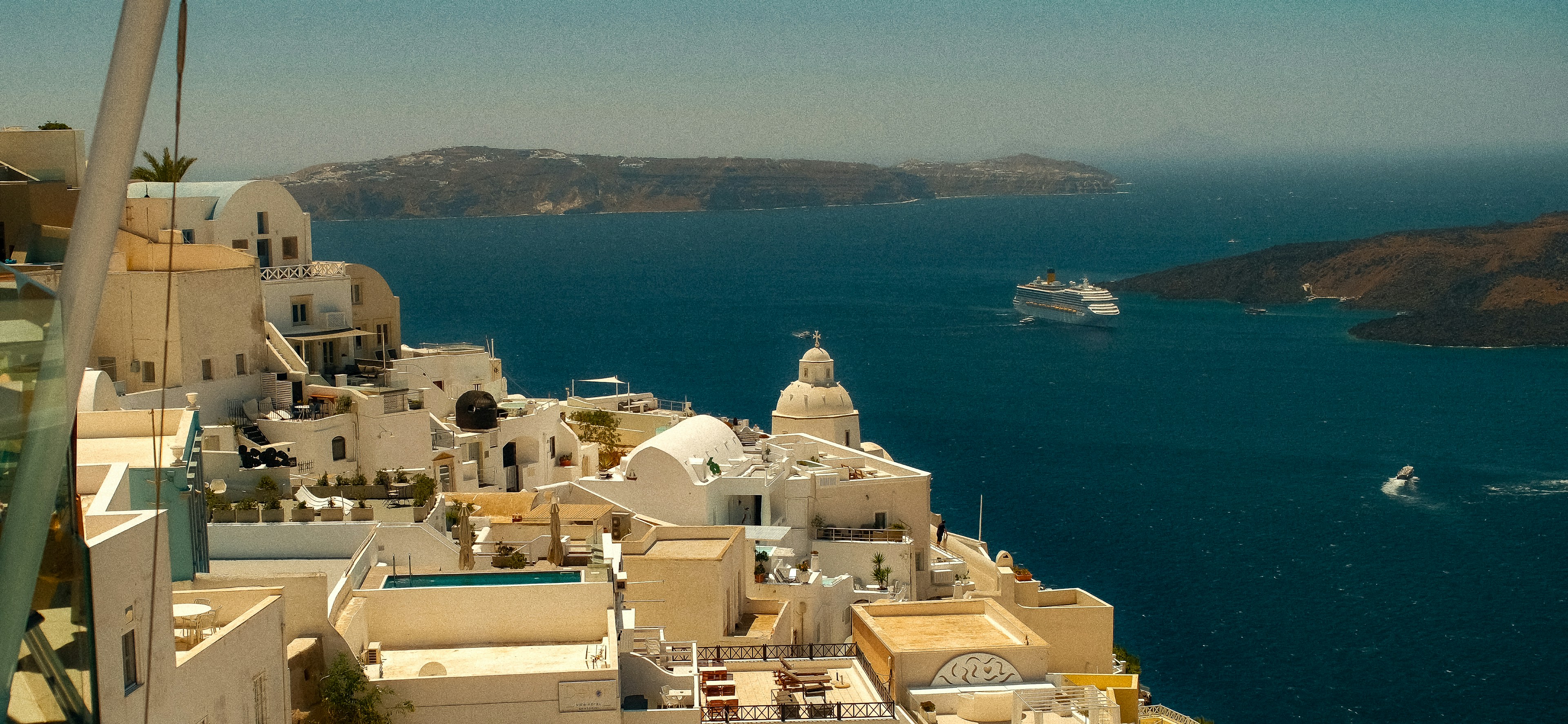 Santorini's Sunlit White Tiers Overlooking Aegean Blue