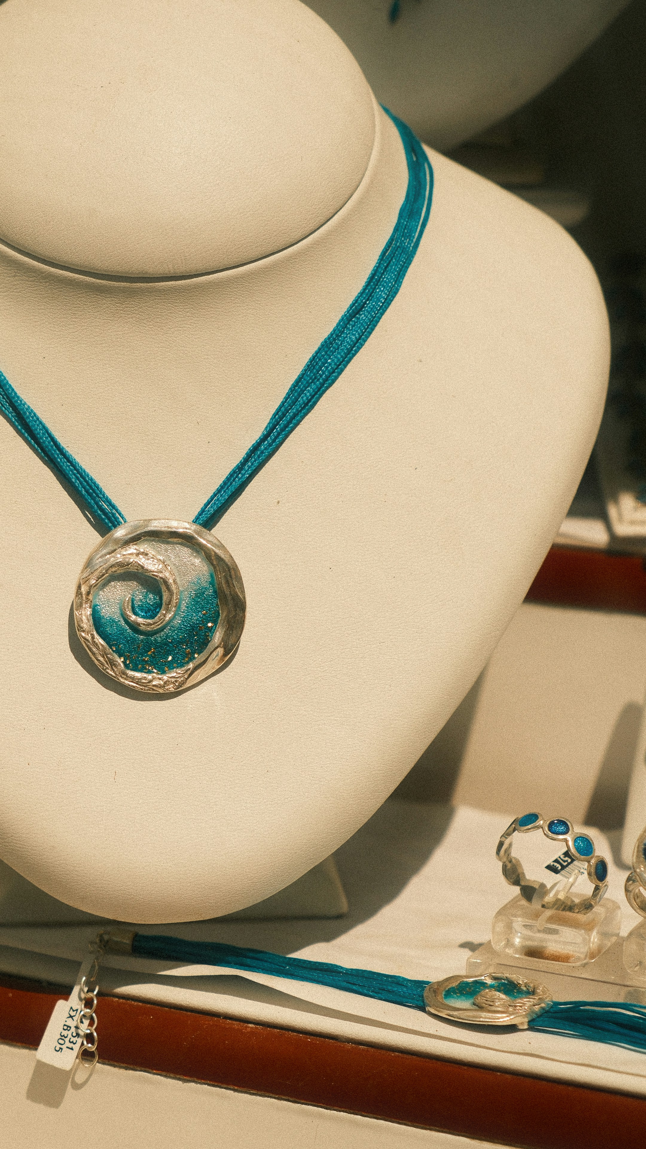 Blue Spiral Pendant on a Teal Cord: A Jewelry Display Moment
