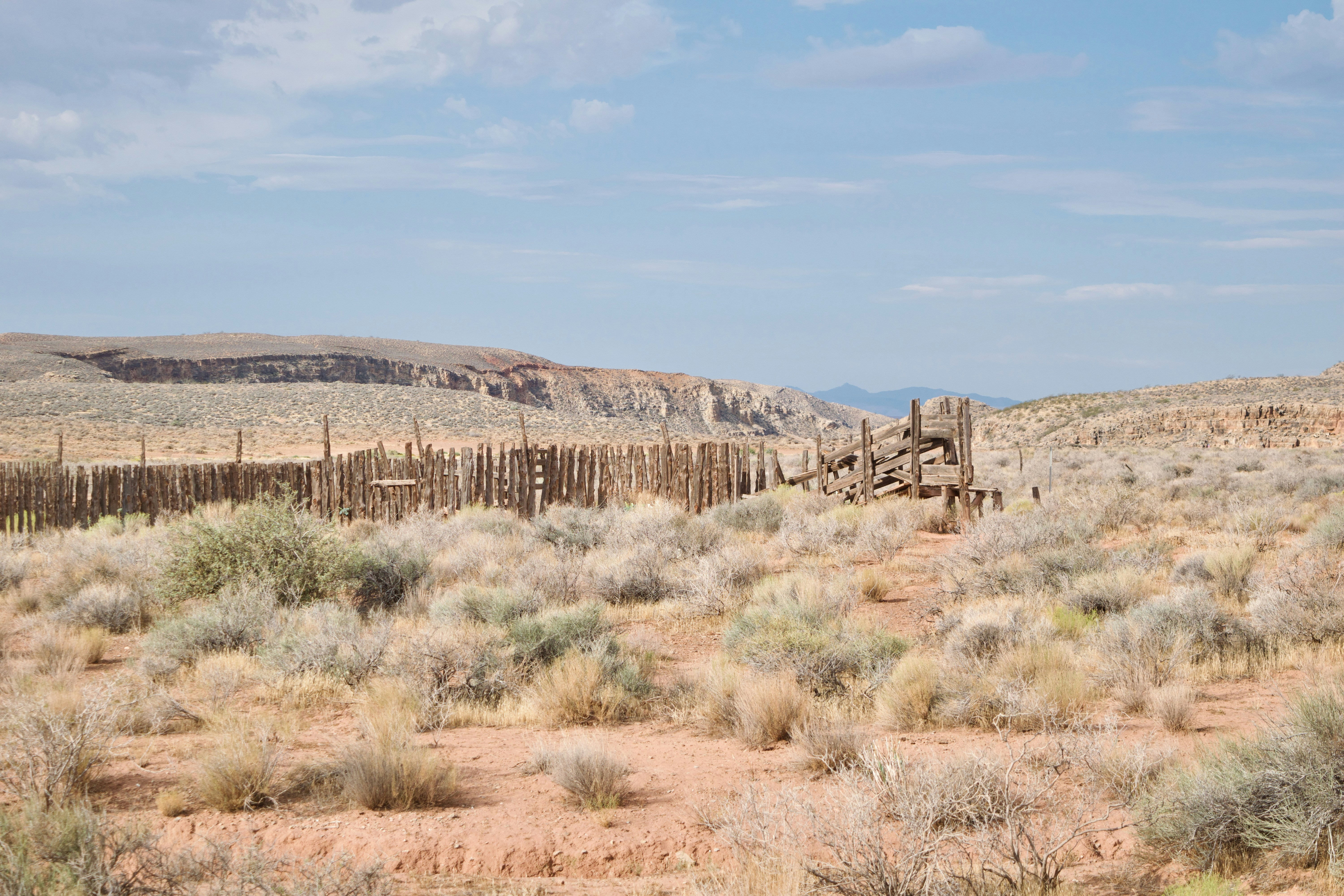 Desert Gate: Weathered Fence Guarding a Distant Ridge