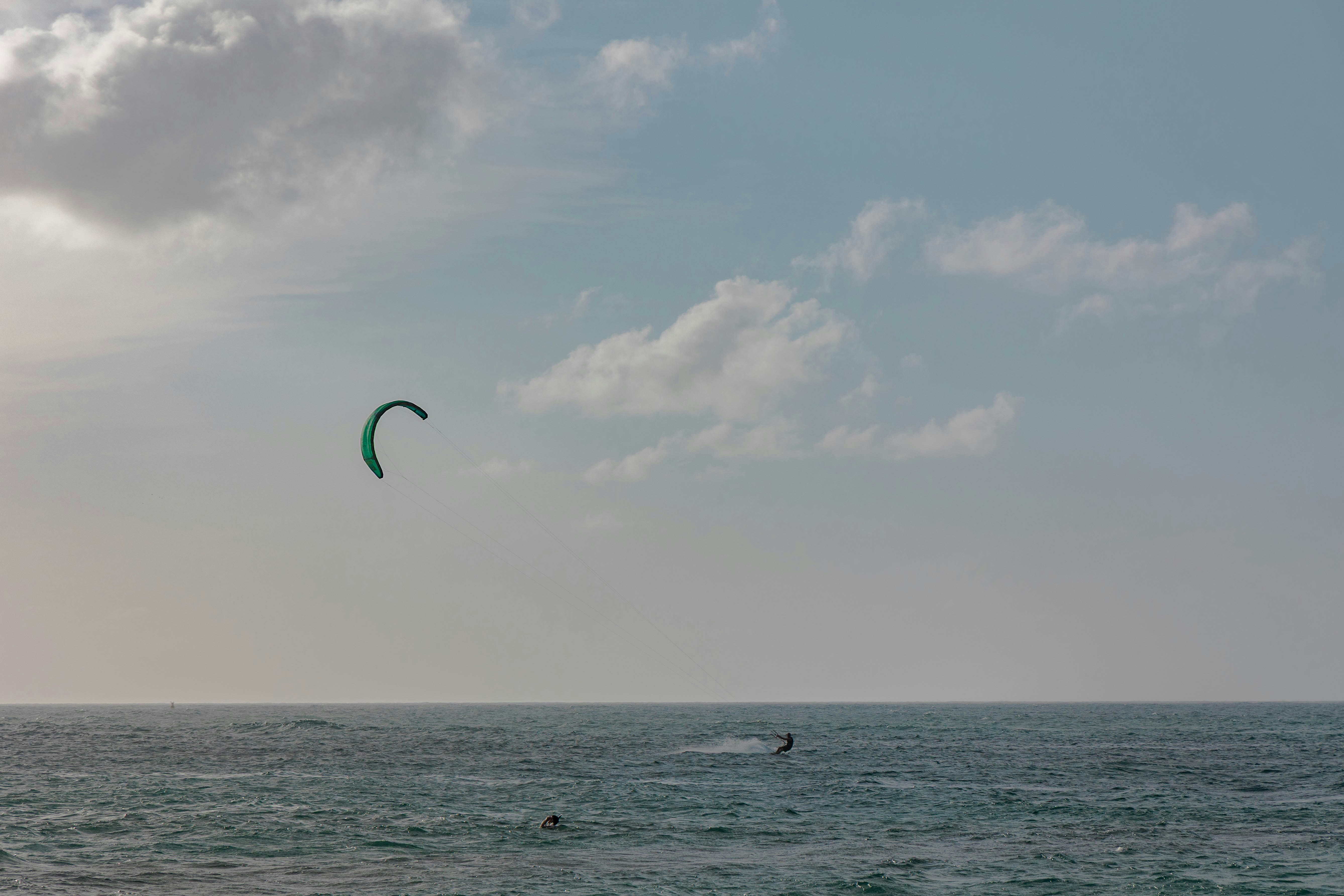 Distant Kite Surfer Over a Calm Sea at Dusk