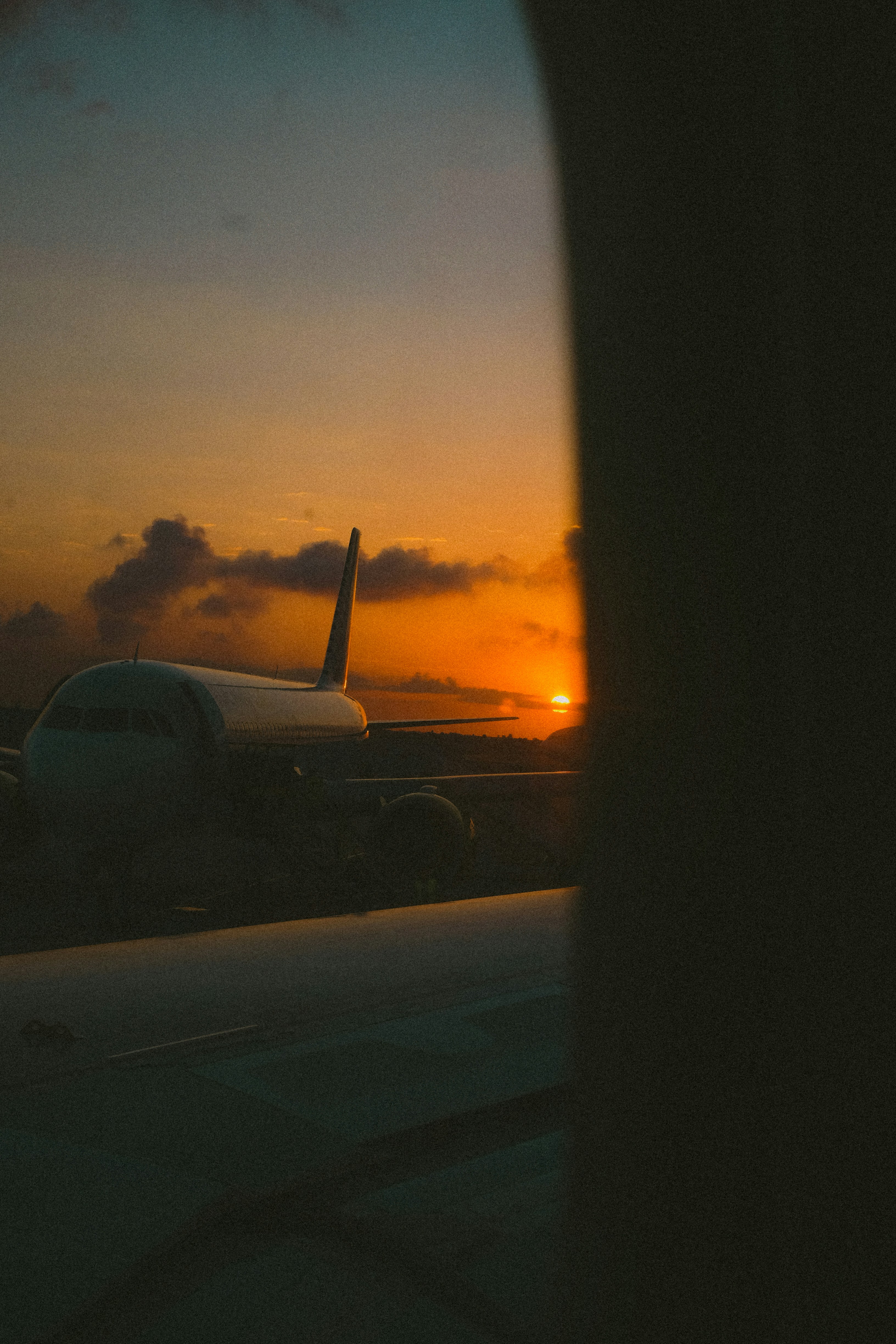 Sunset Gate: A Quiet Aircraft at Dusk Through a Window