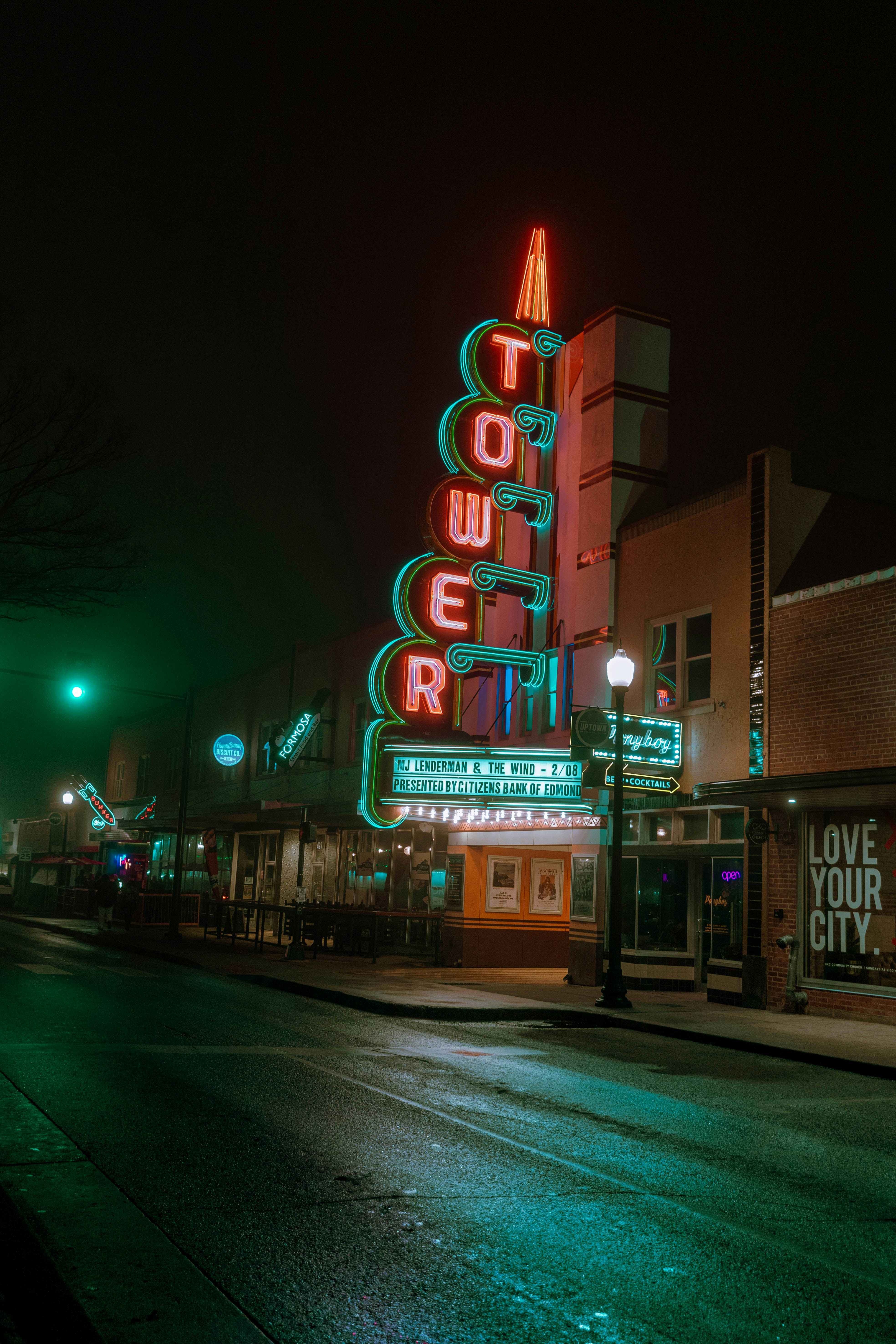 Neon Theater Sign Illuminates a Quiet Street at Night