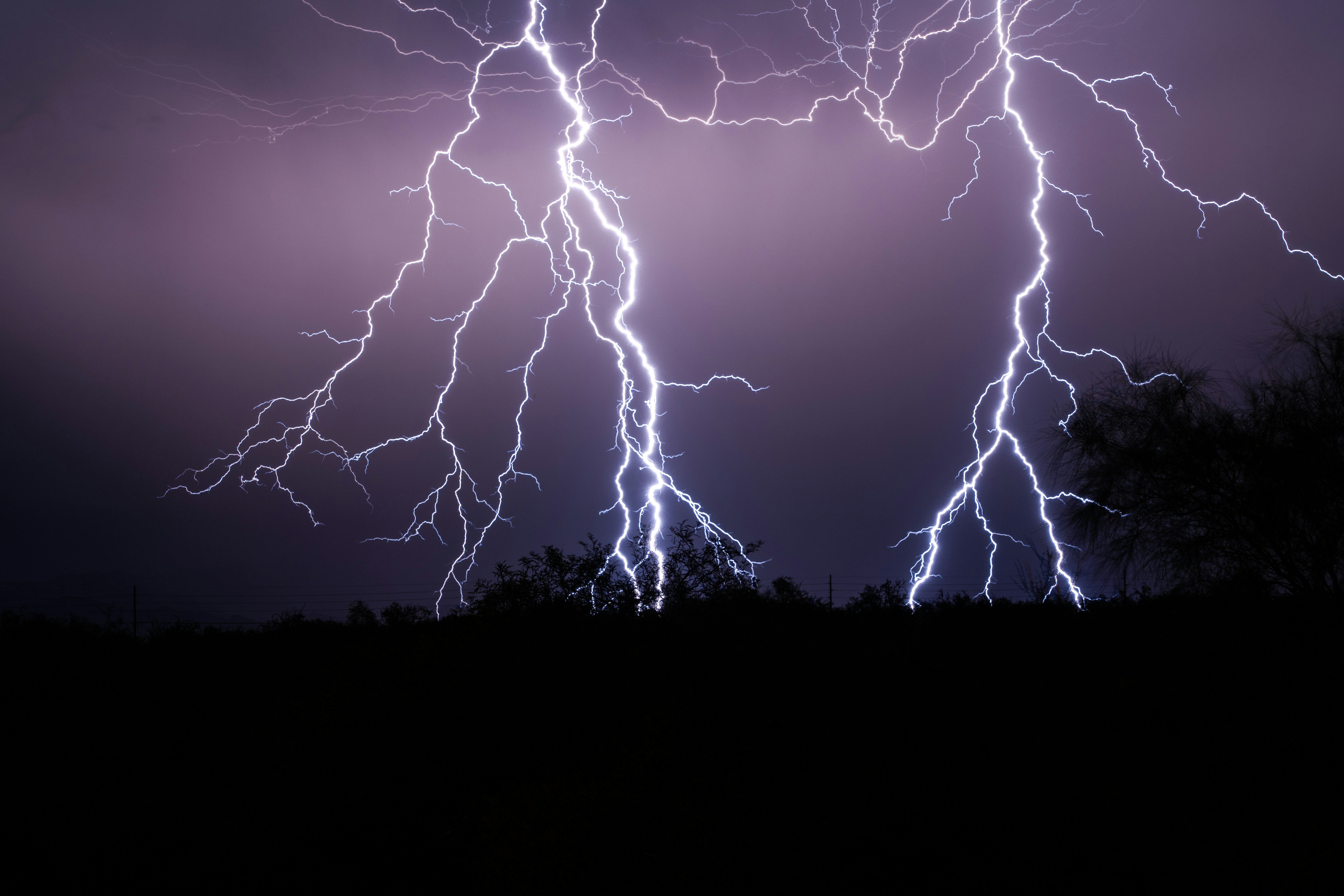 Lightning Arcs Over a Silhouette: Night Sky Sparks on the Horizon