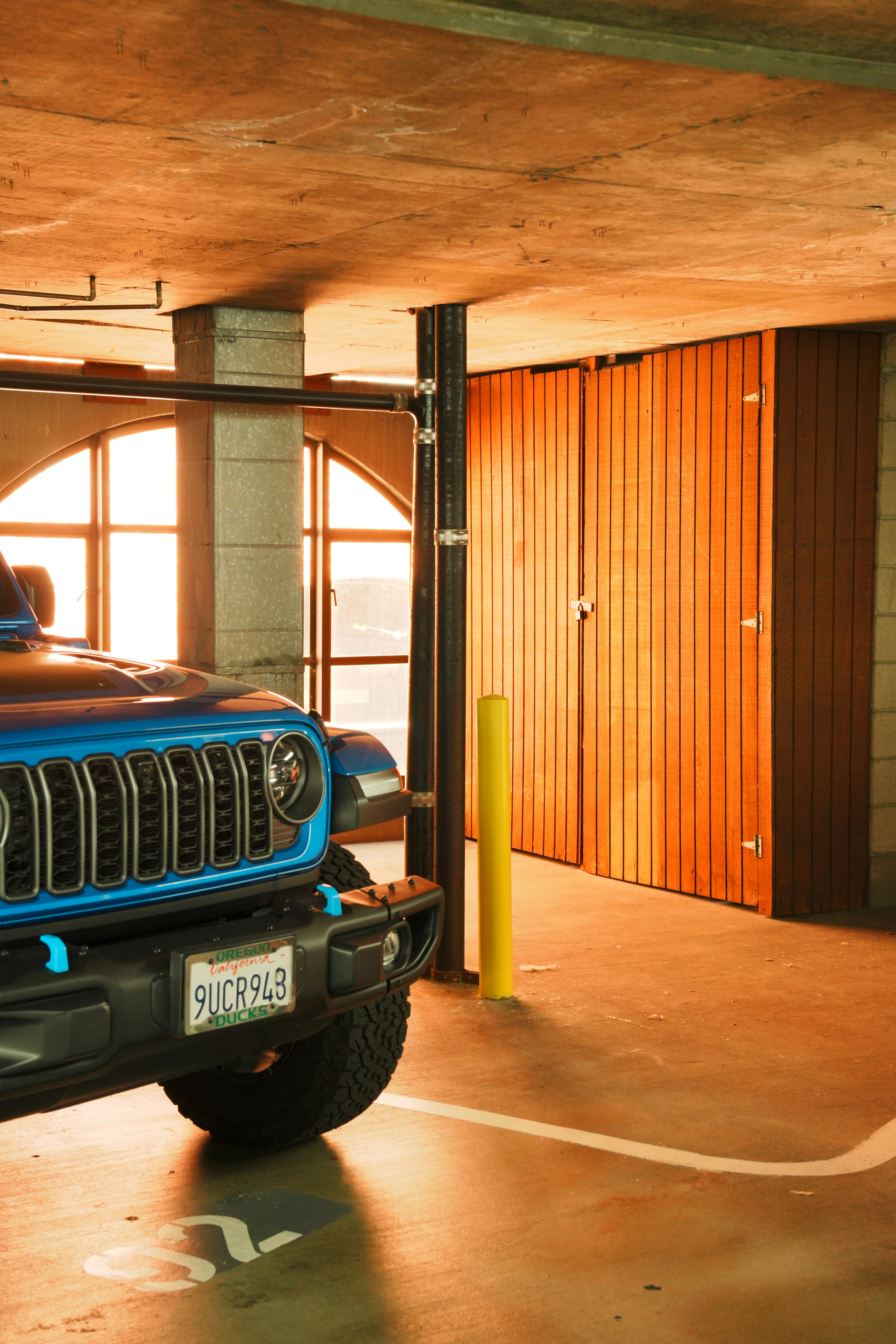 Blue Jeep Rising from a Parking Garage Shadow