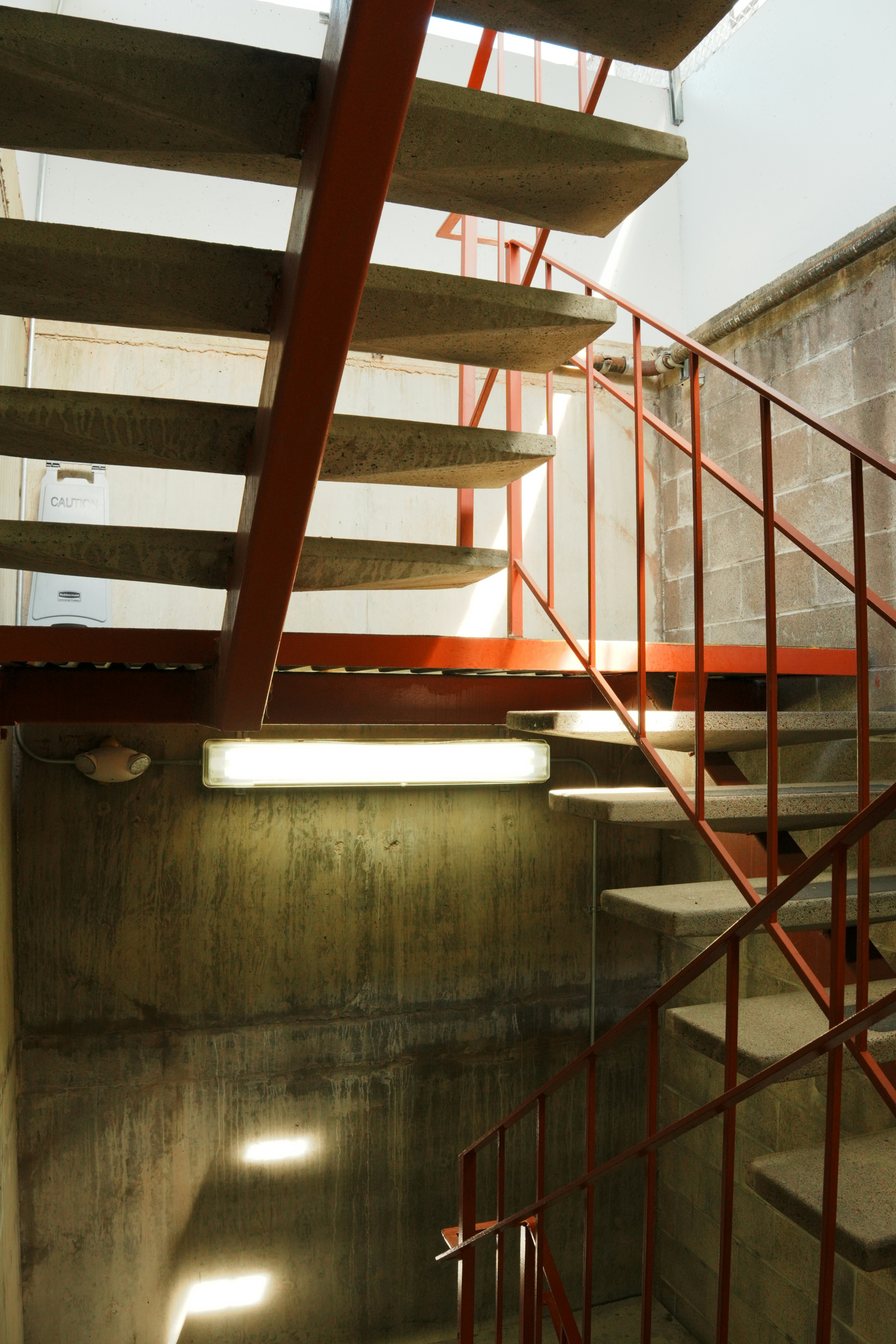 Red Staircase Portrait: Geometry, Light, and Concrete Echoes