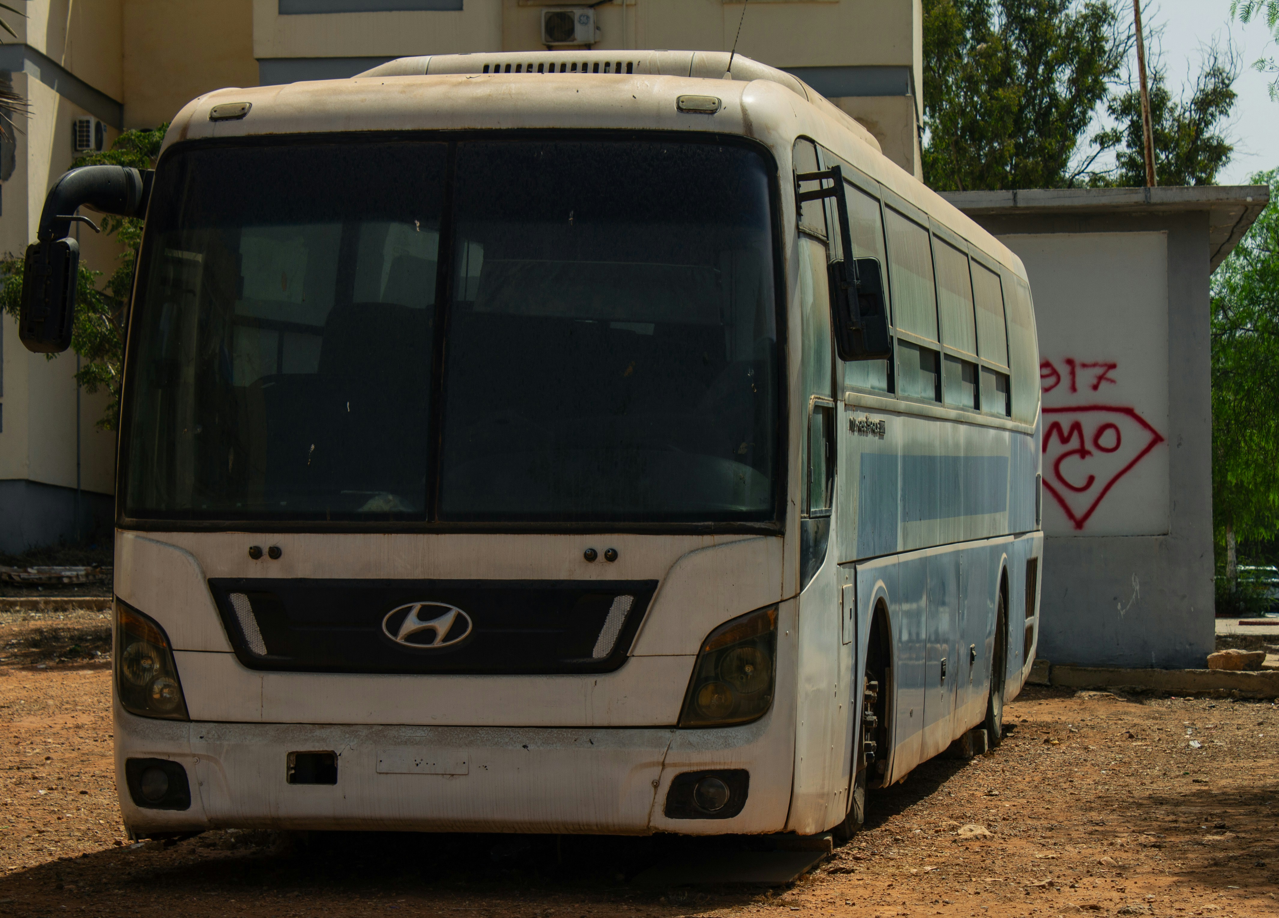 Sun-bleached Tourist Bus Resting by the Dilapidated Wall