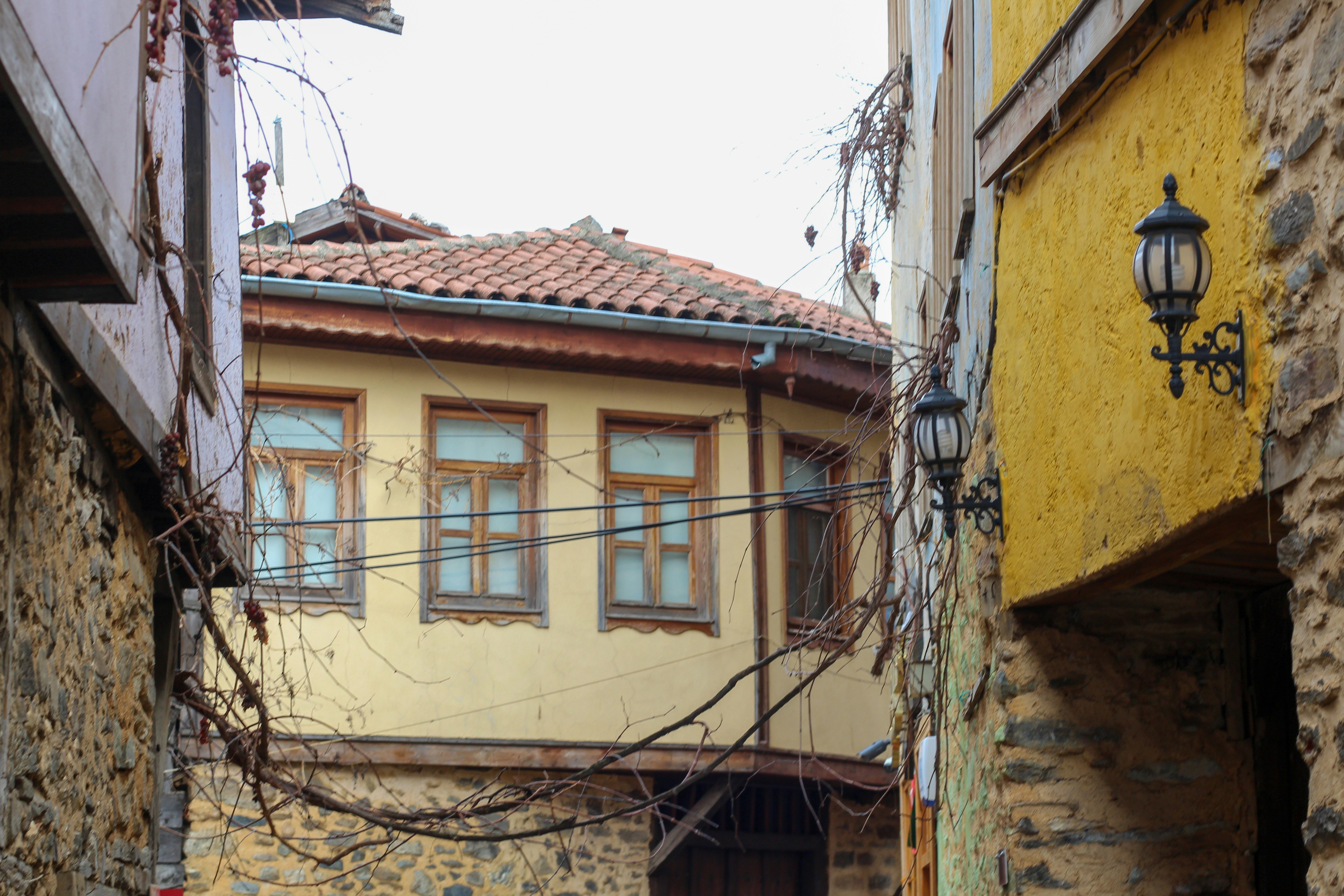 Sunlit Yellow Facade Overlooked by Narrow Alley