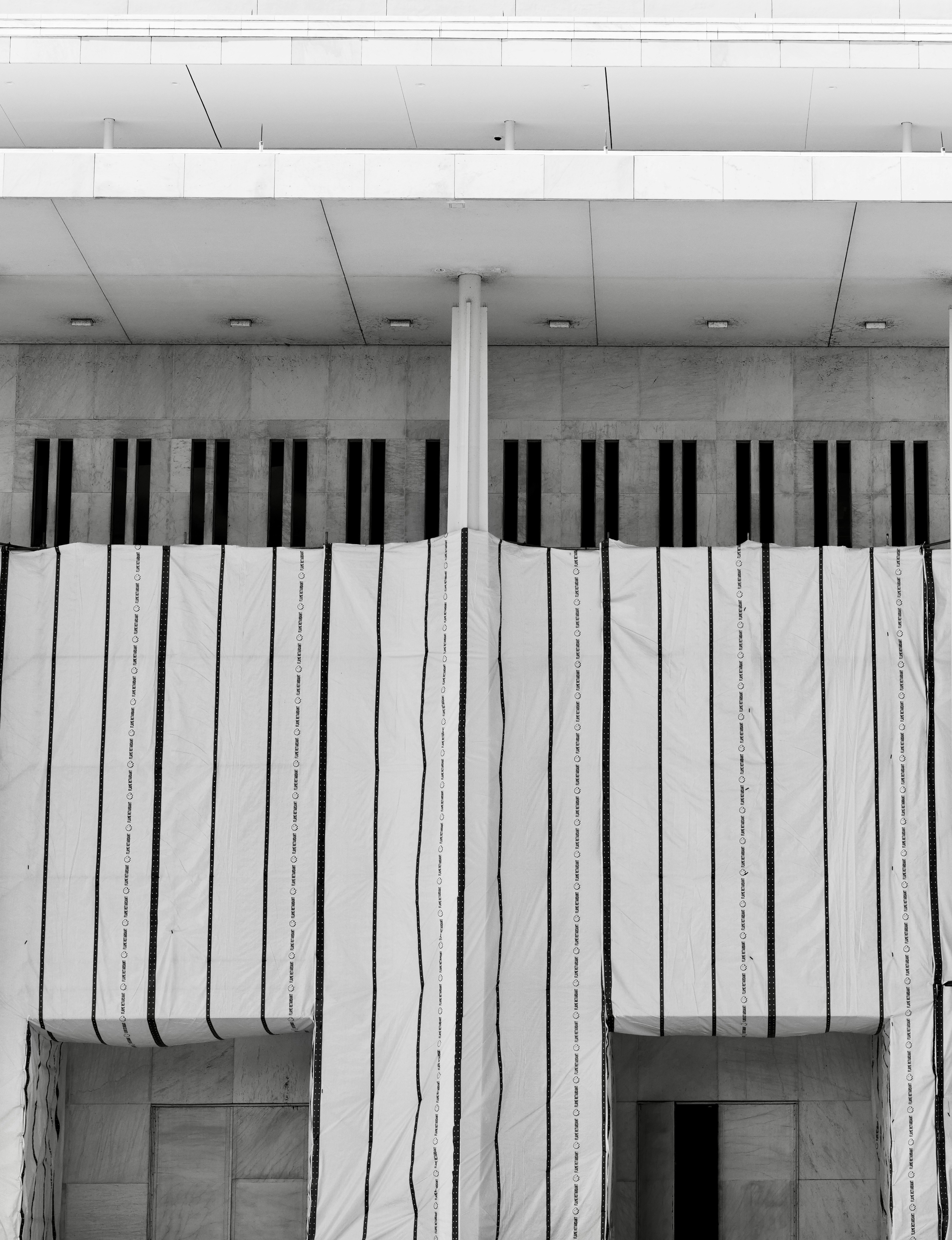 Monolithic Facade: Vertical Stripes and Central Column Scripted in Concrete
