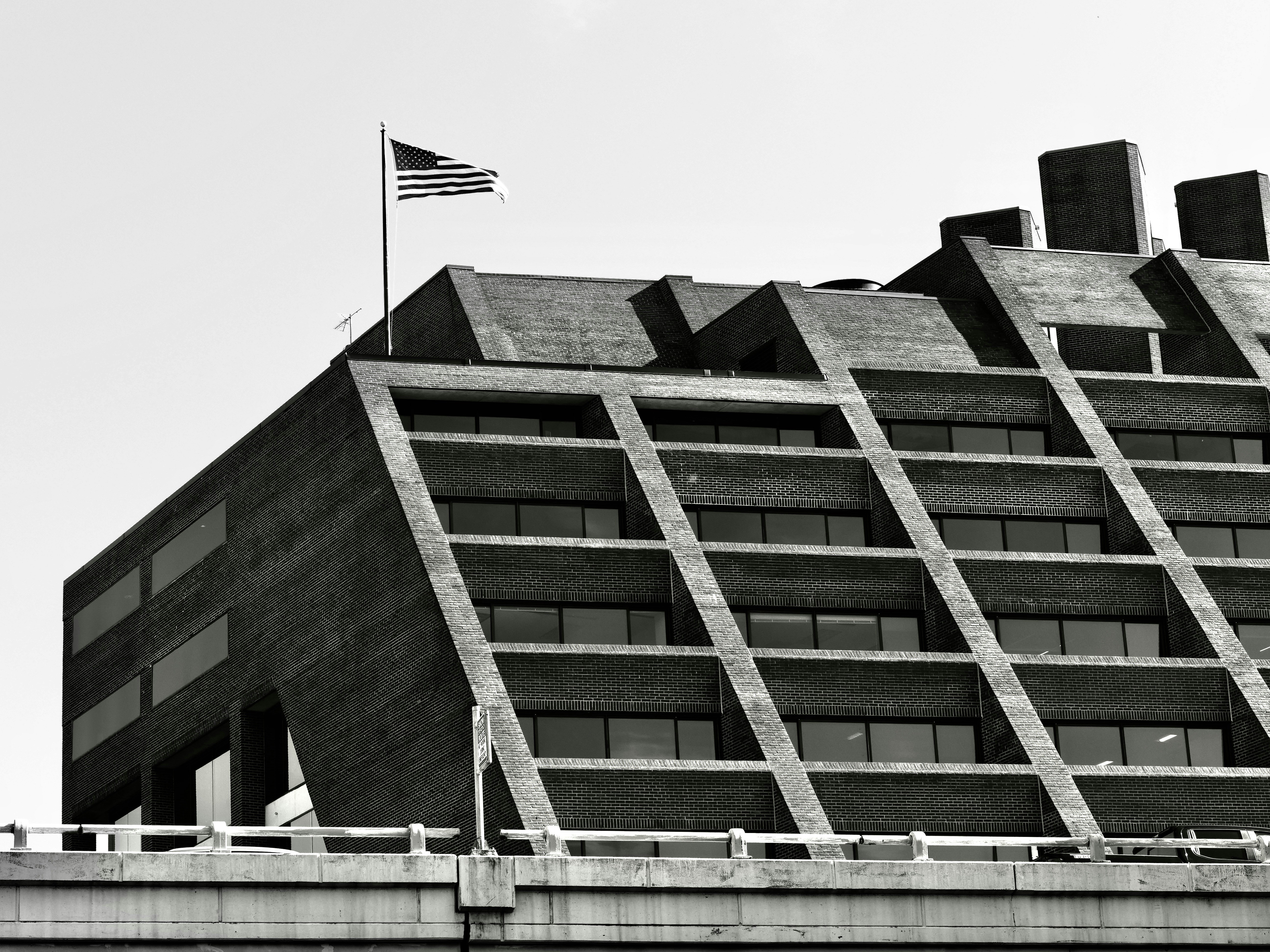 Flag over Brutalist Facade: Angled Concrete and Lines