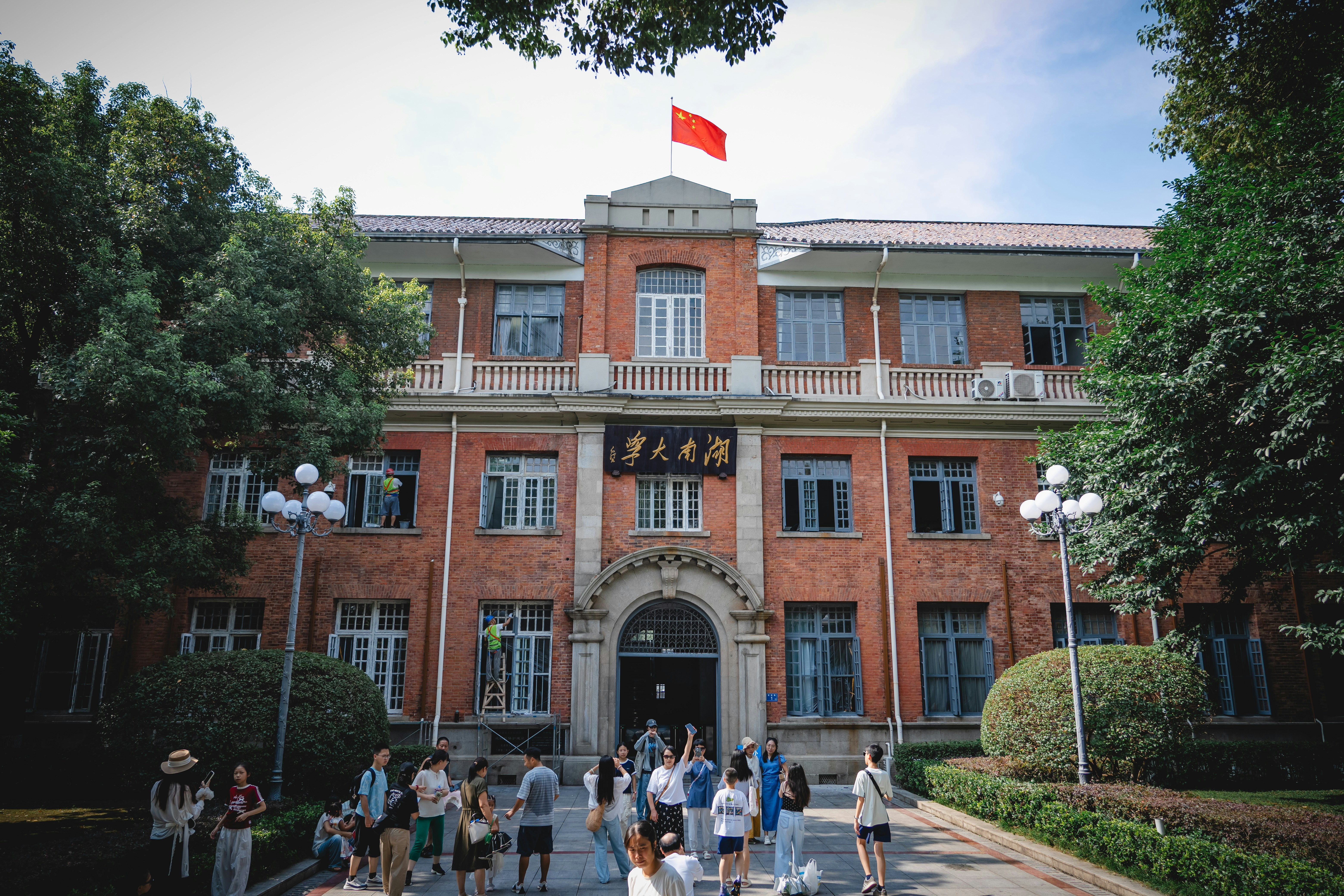 Flag Over the Historic Campus Gate as Students Gather Below
