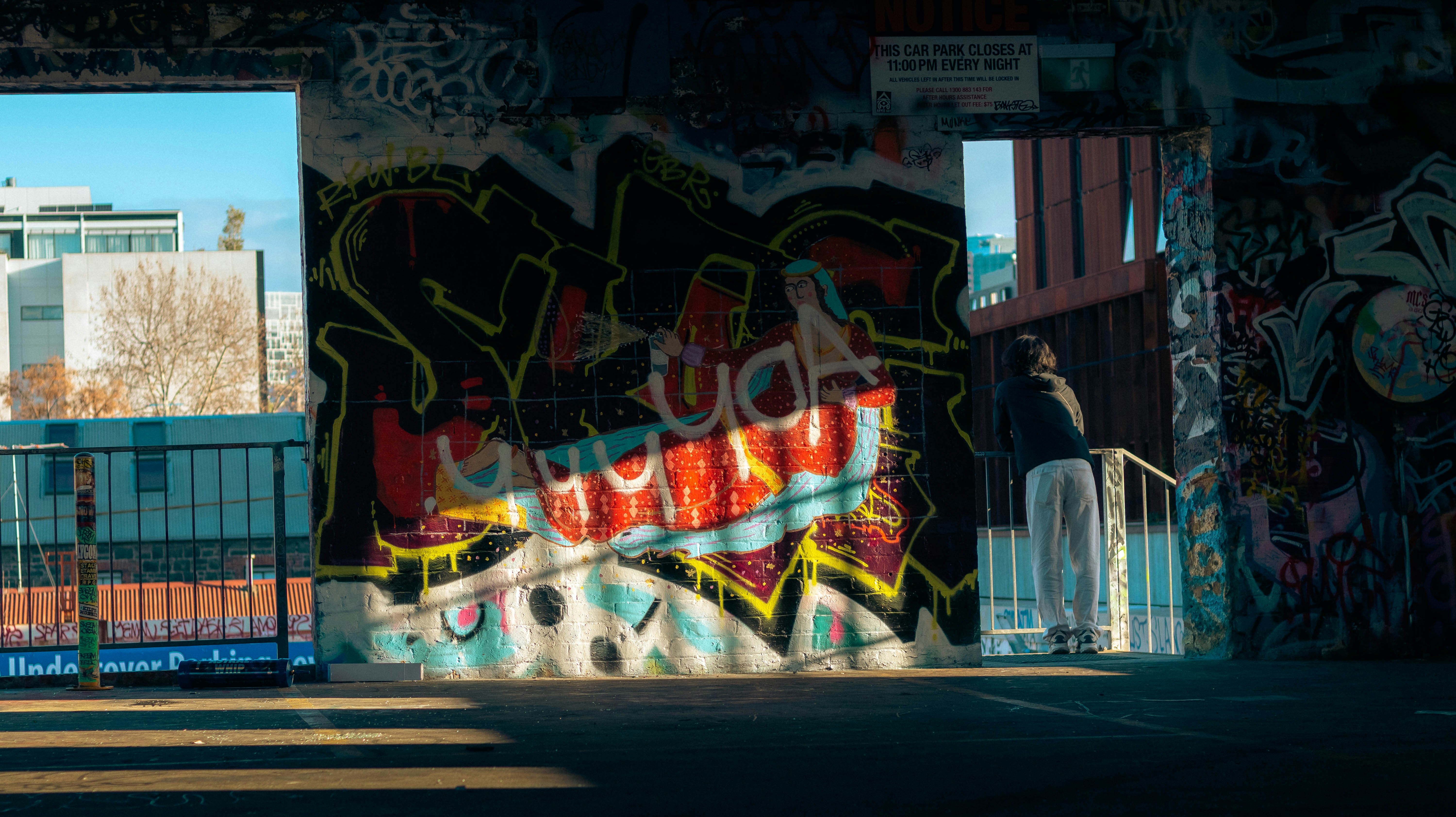 Graffitied Underpass: Hidden Figure in the Afternoon Shade