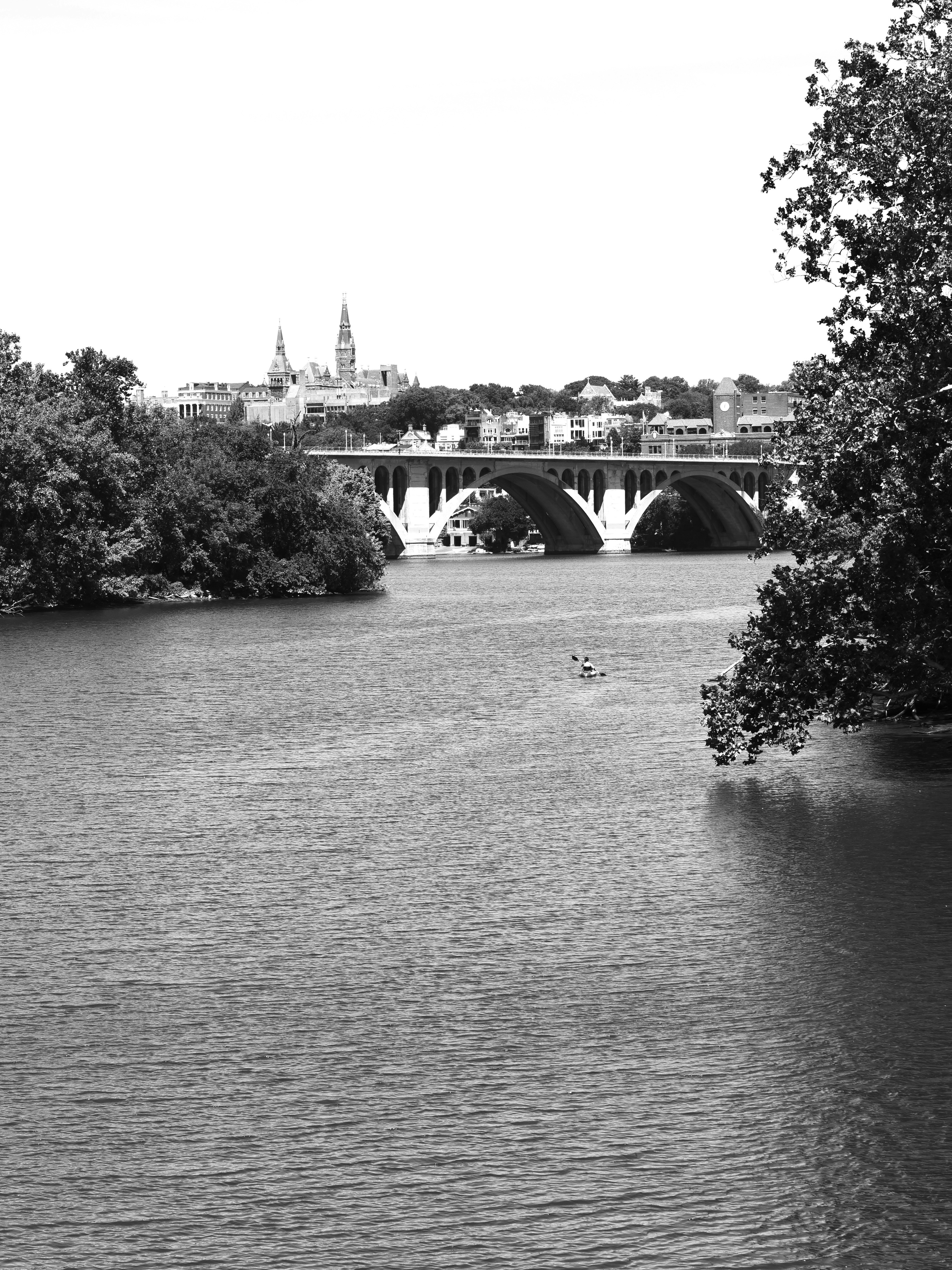 Toward the Arched Horizon: A Calm Riverside Scene with a City Bridge