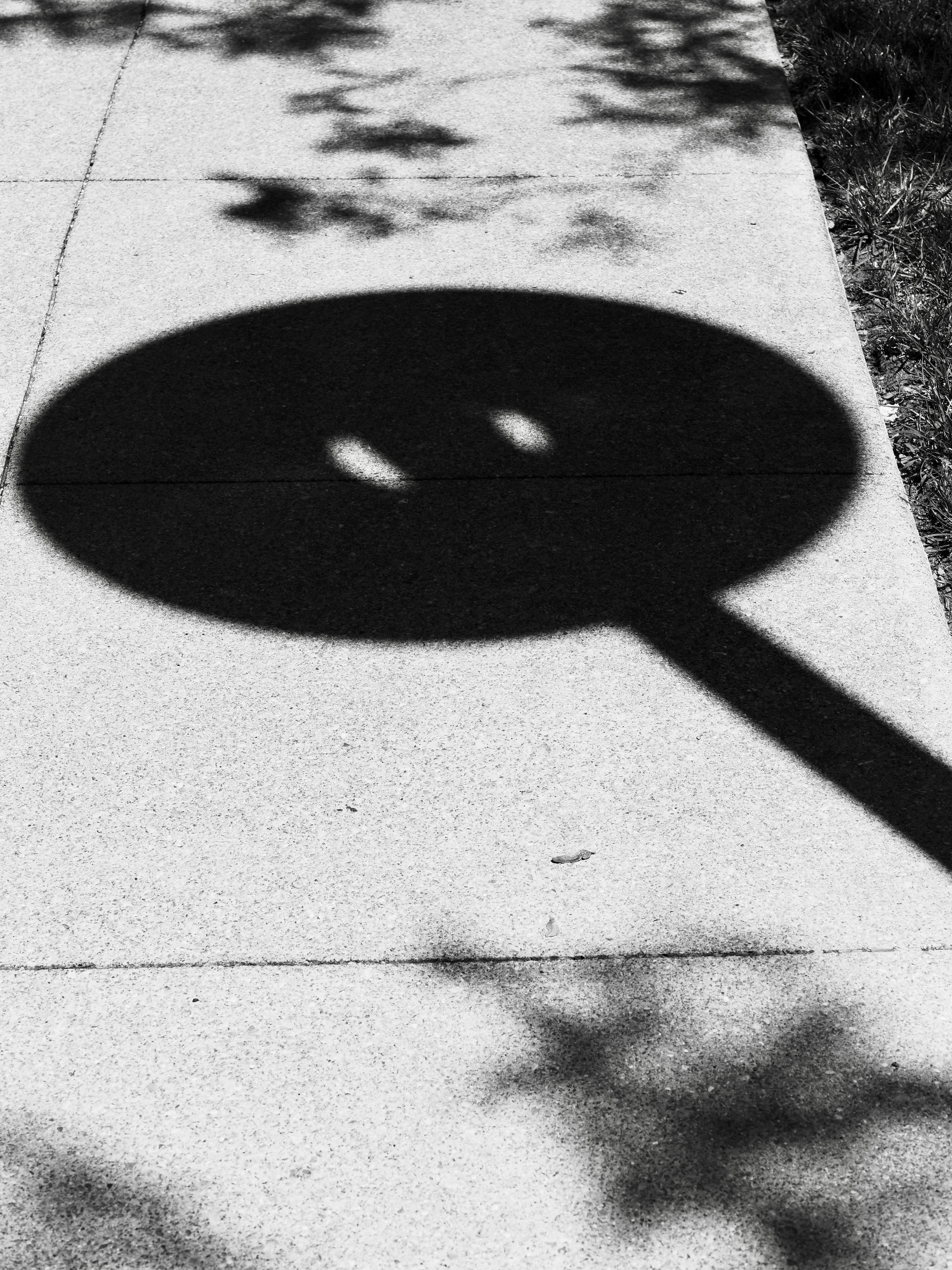 Shadowed Signpost: A Large Street Lamp Shadow Cast on Concrete
