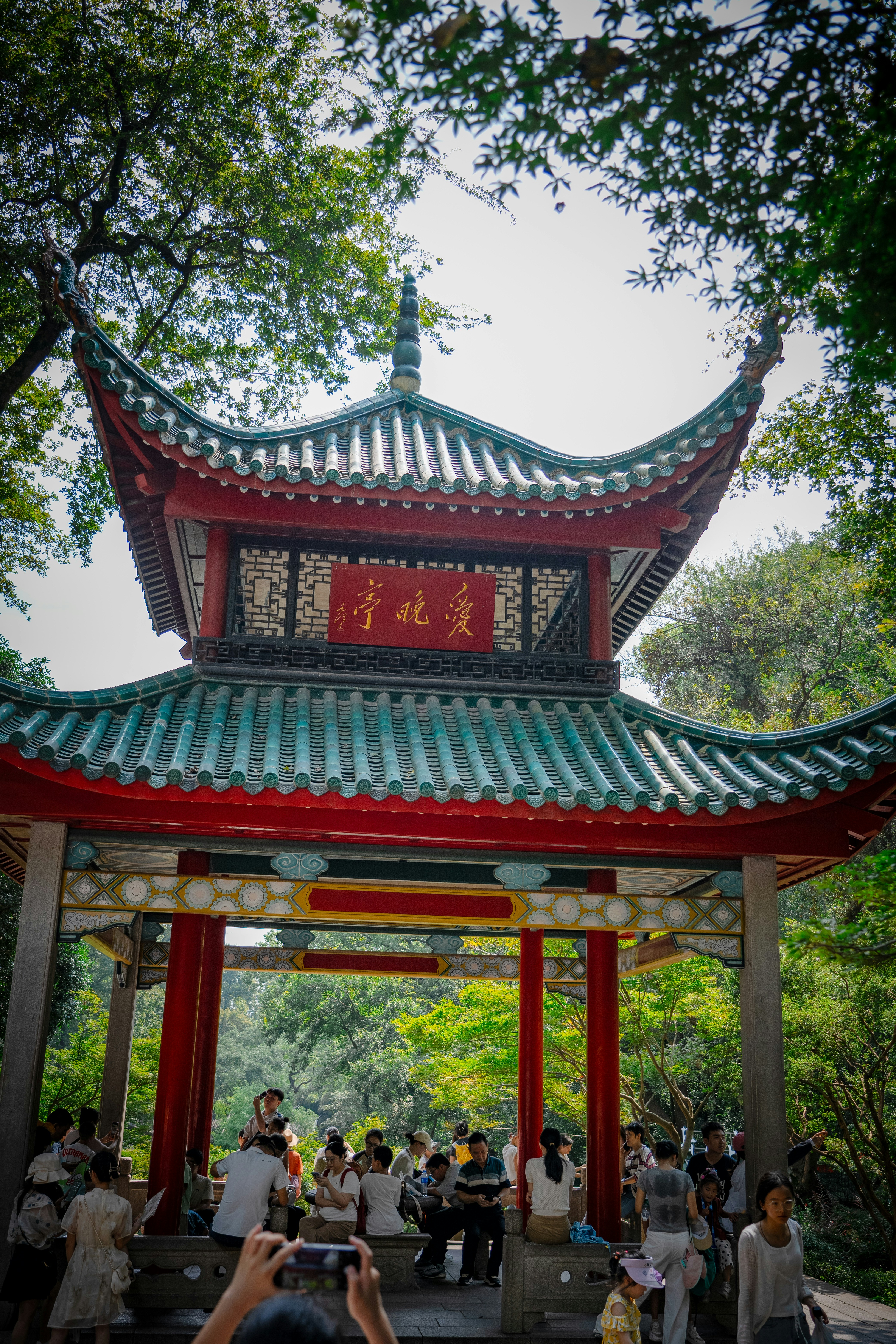 Ceremonial Rooflines: A Pagoda Gate Framed by Crowd in a Garden