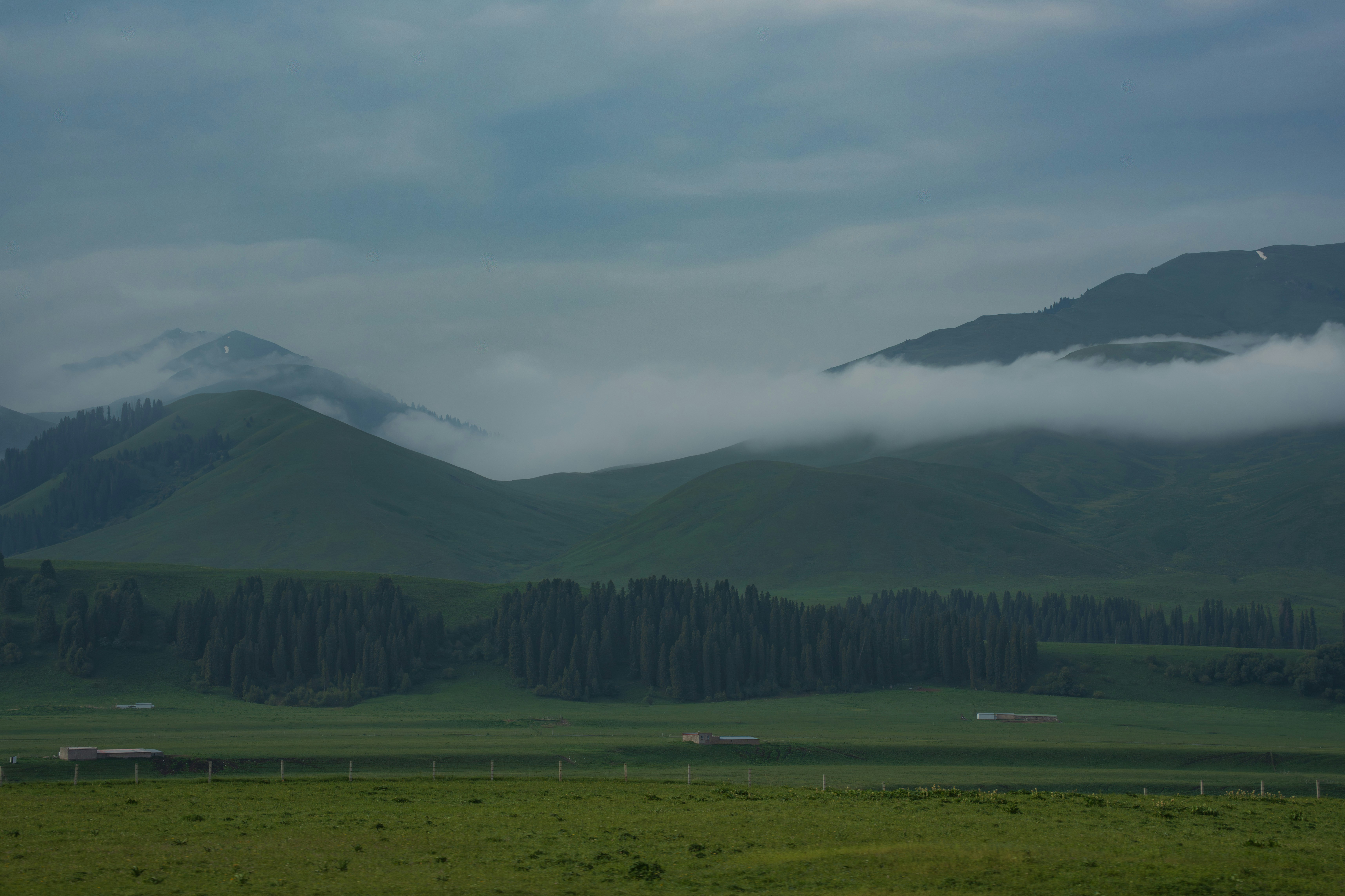 Mist on the rolling foothills under distant peaks