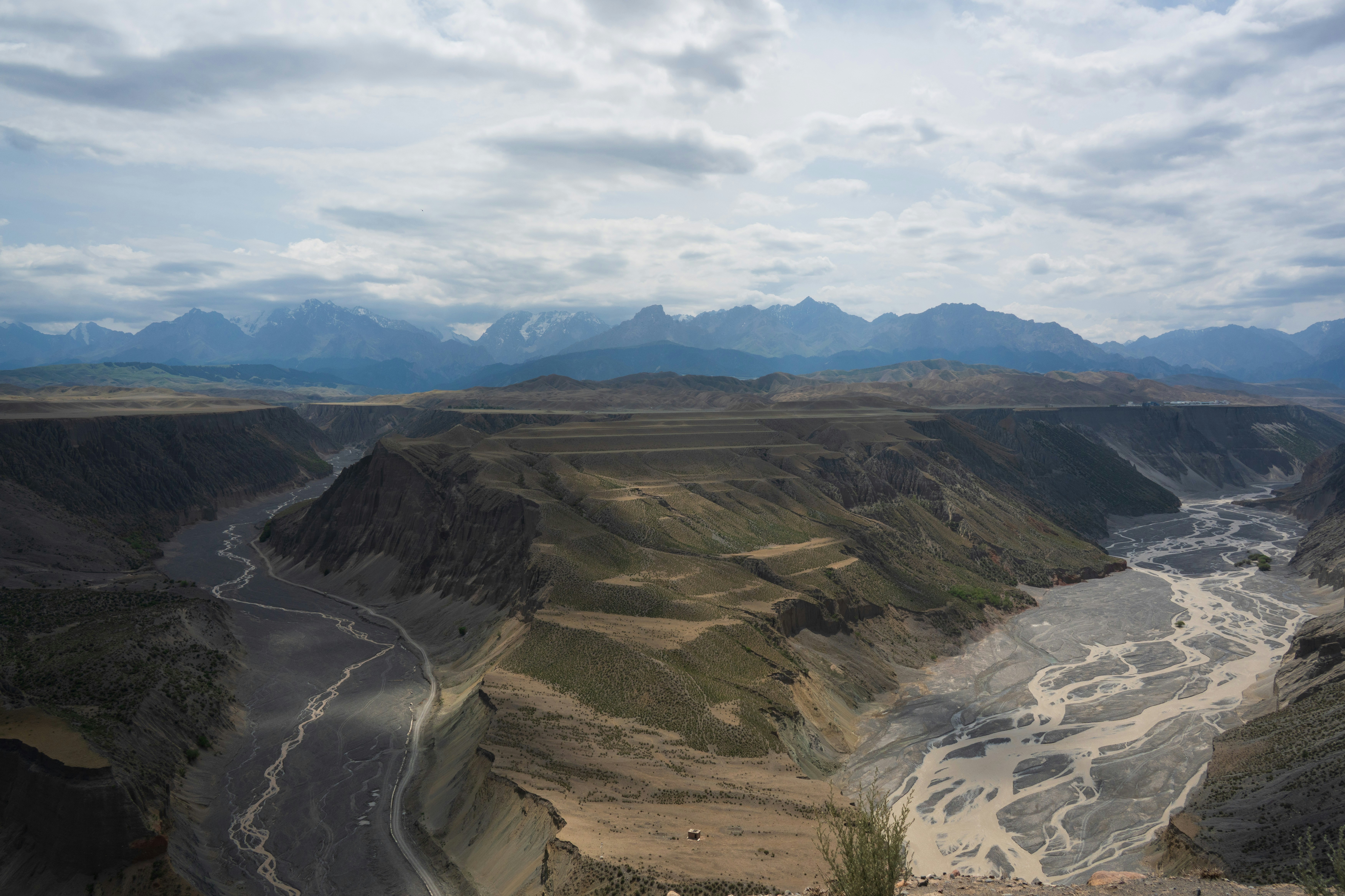 Chiseled Valley with Meandering Rivers under a Clouded Sky