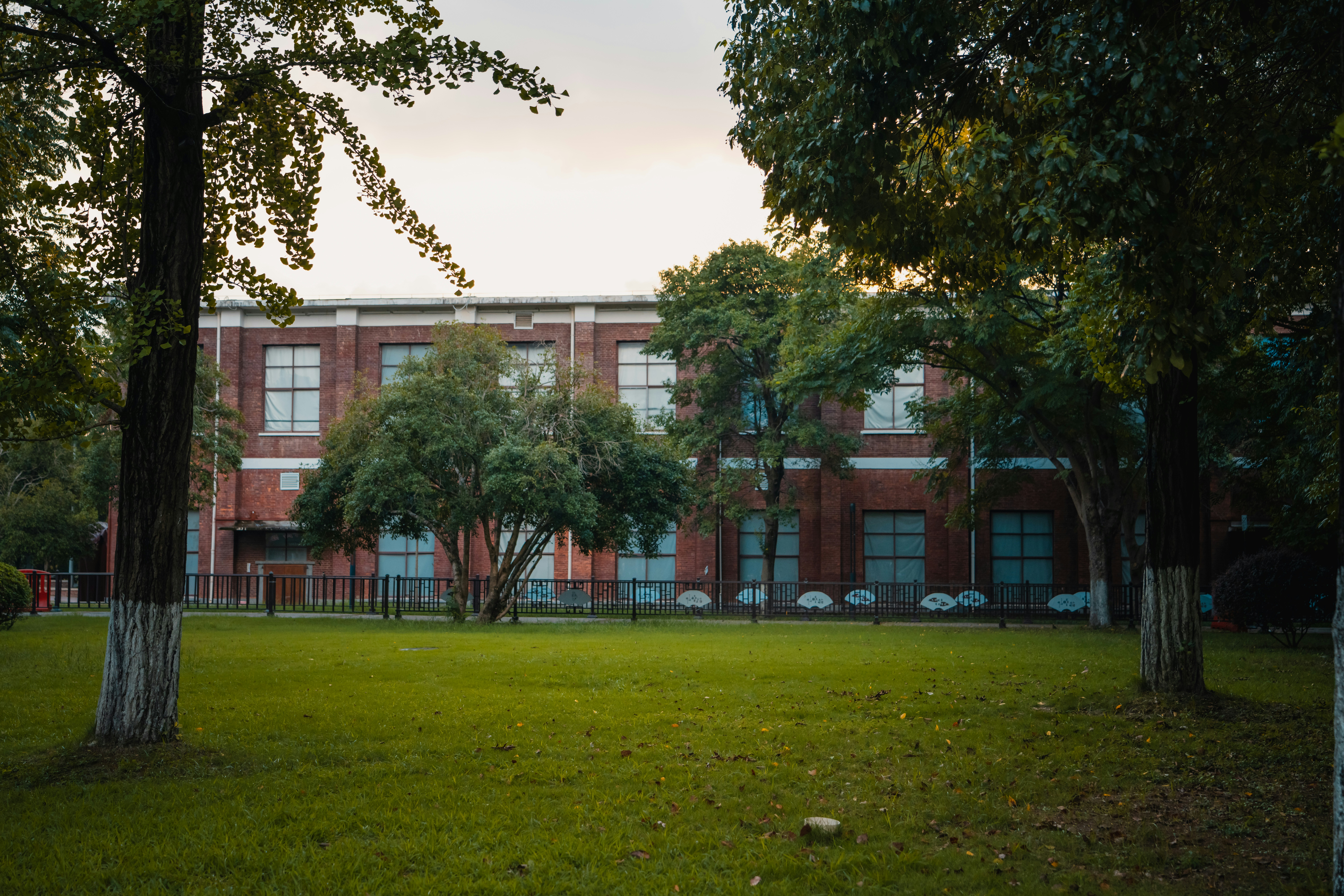 Campus Courtyard at Dusk: Brick Building Framed by Trees