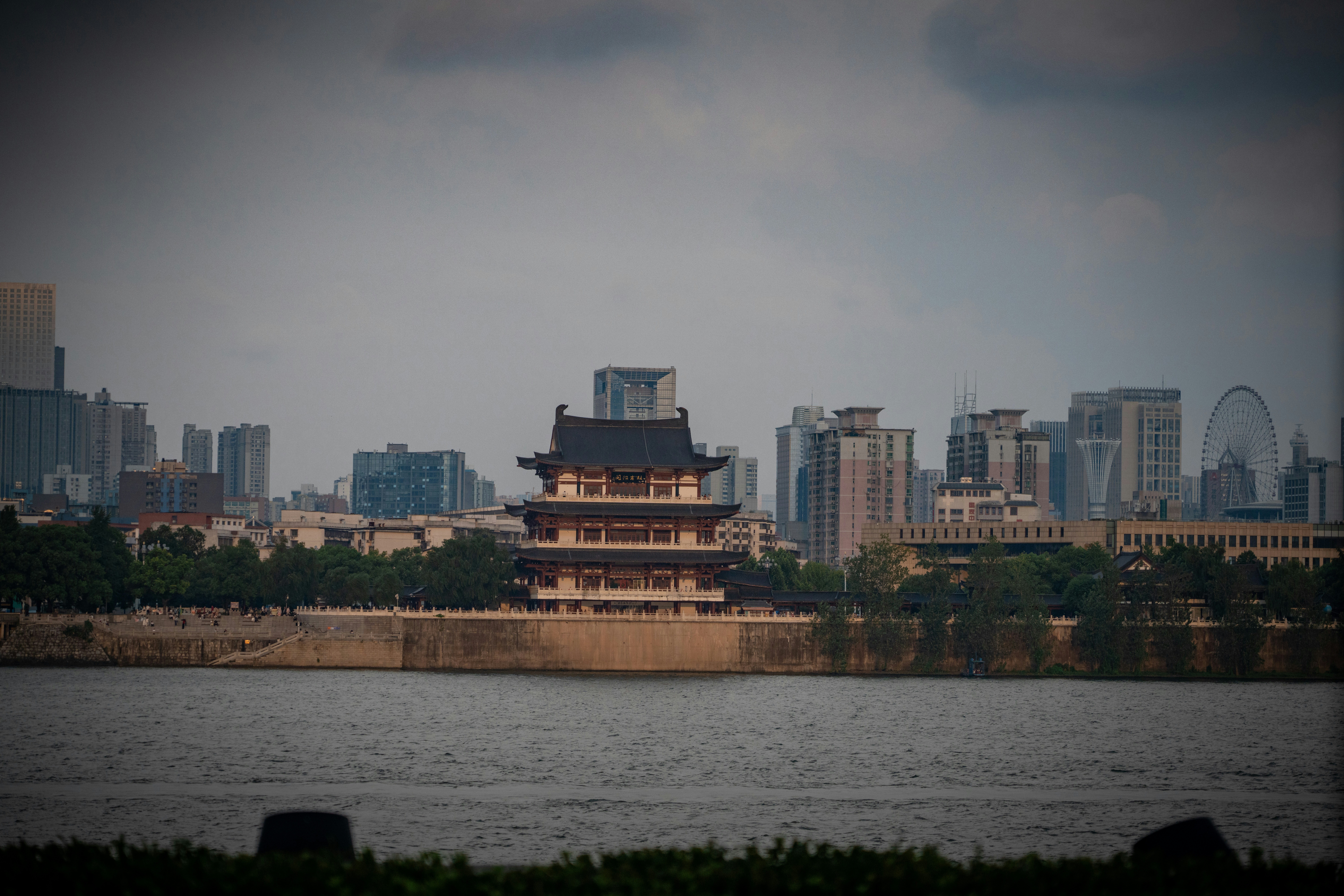 Pagoda by the River: Ancient Structure Amid Modern Skyline